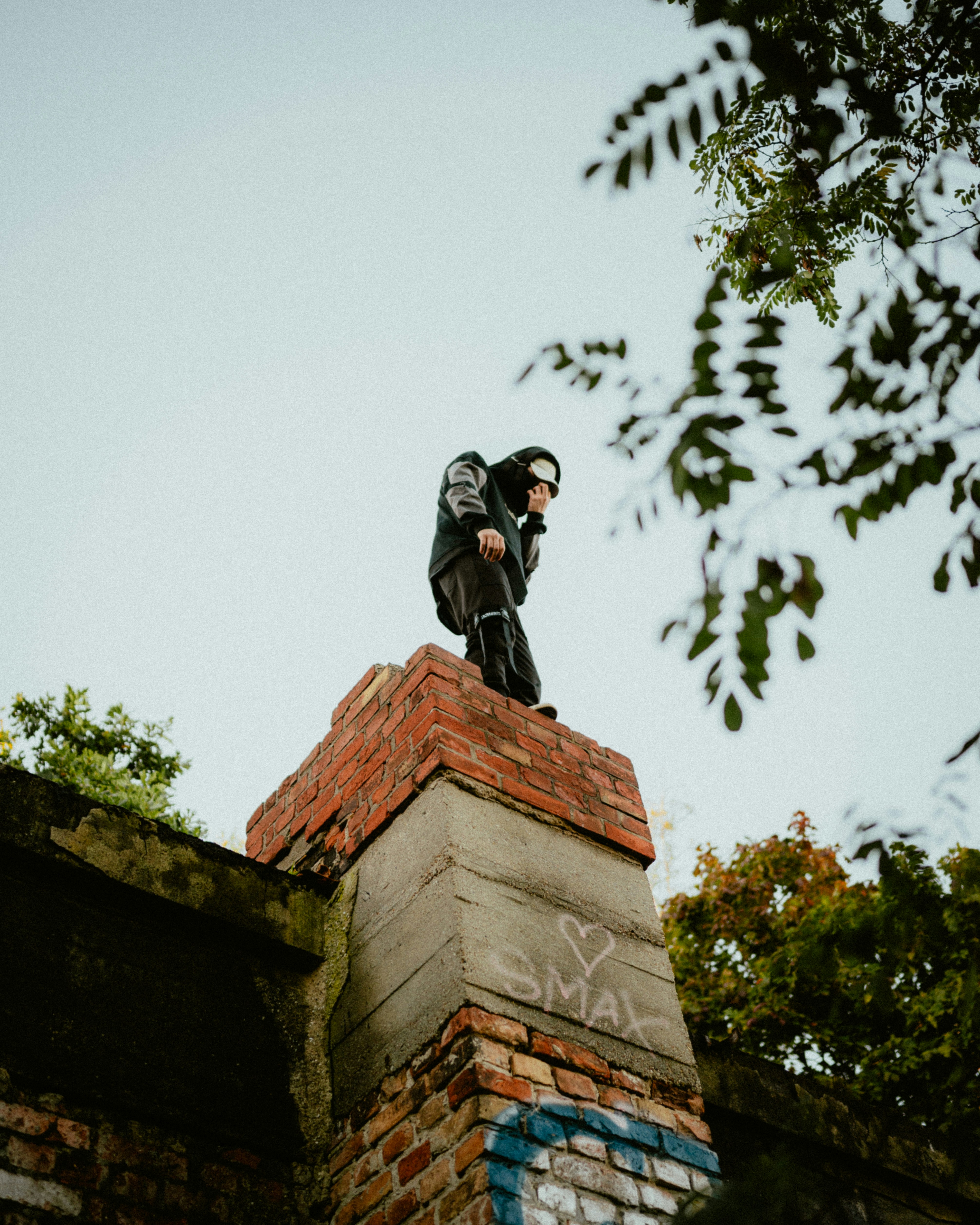 Edge of the Brick: A Figure Stands atop a Weathered Pillar