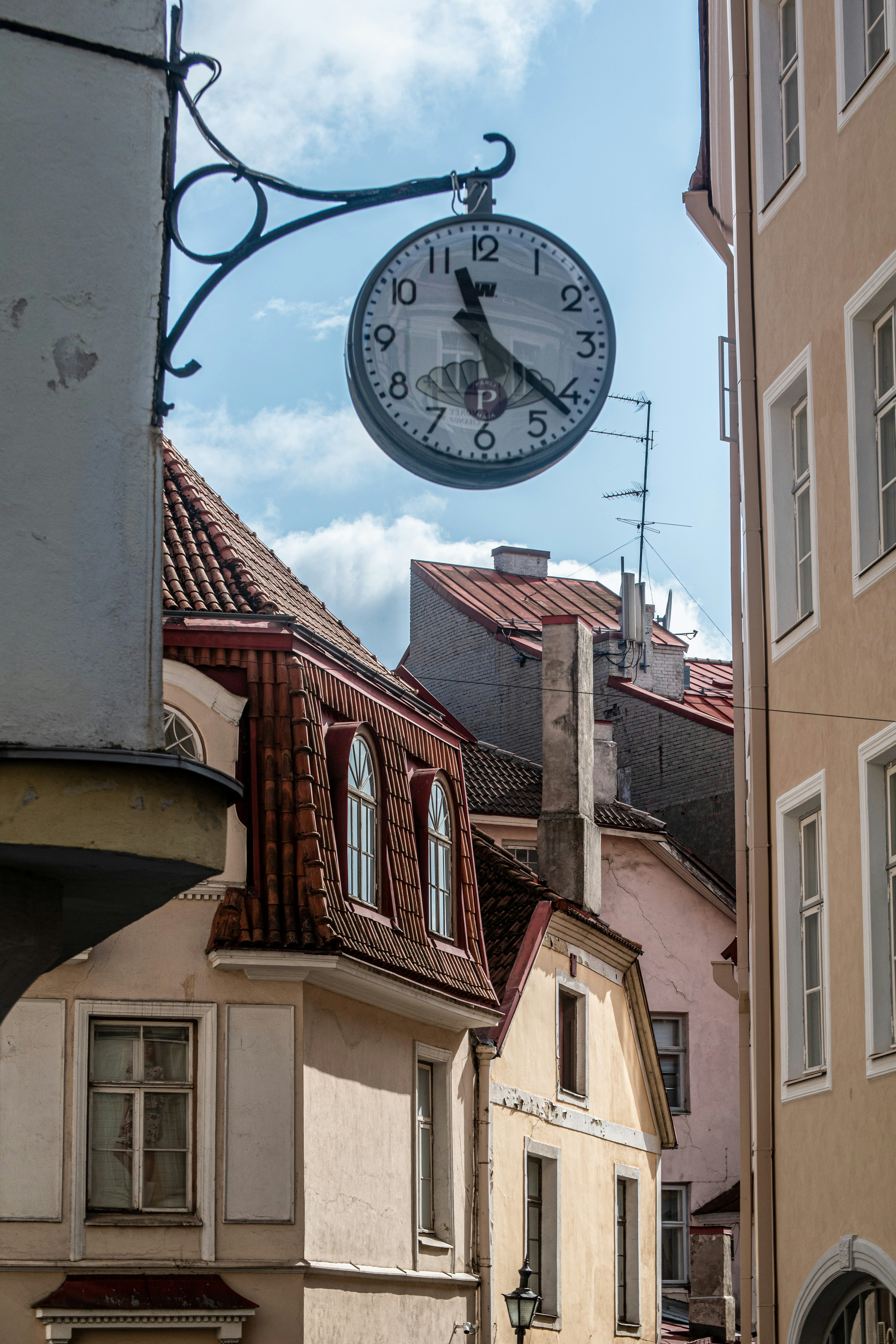 Timekeeper Over Tiles: A Sunlit European Street Clock