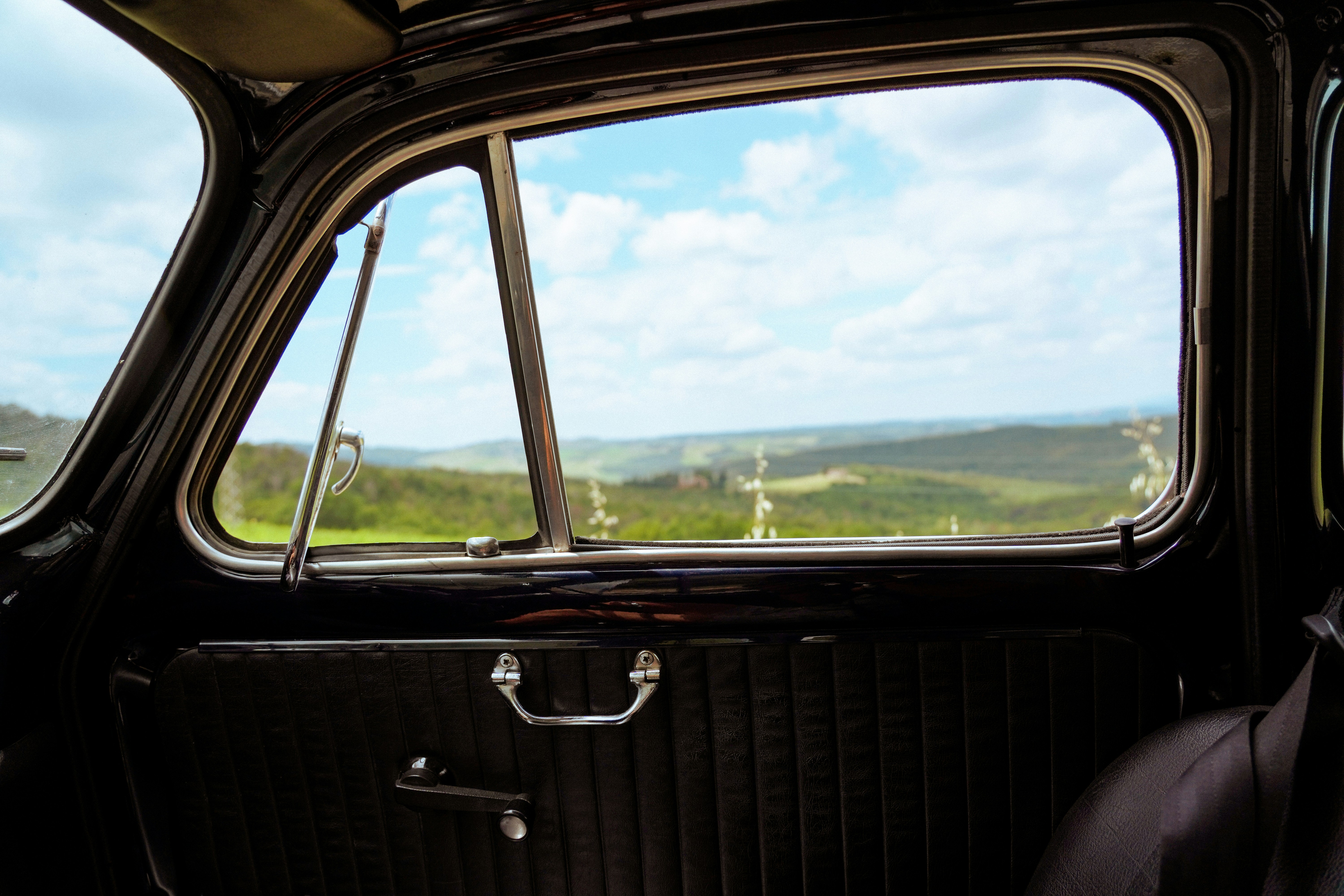 Past the Window: Distant Hills Through a Classic Car Cabin