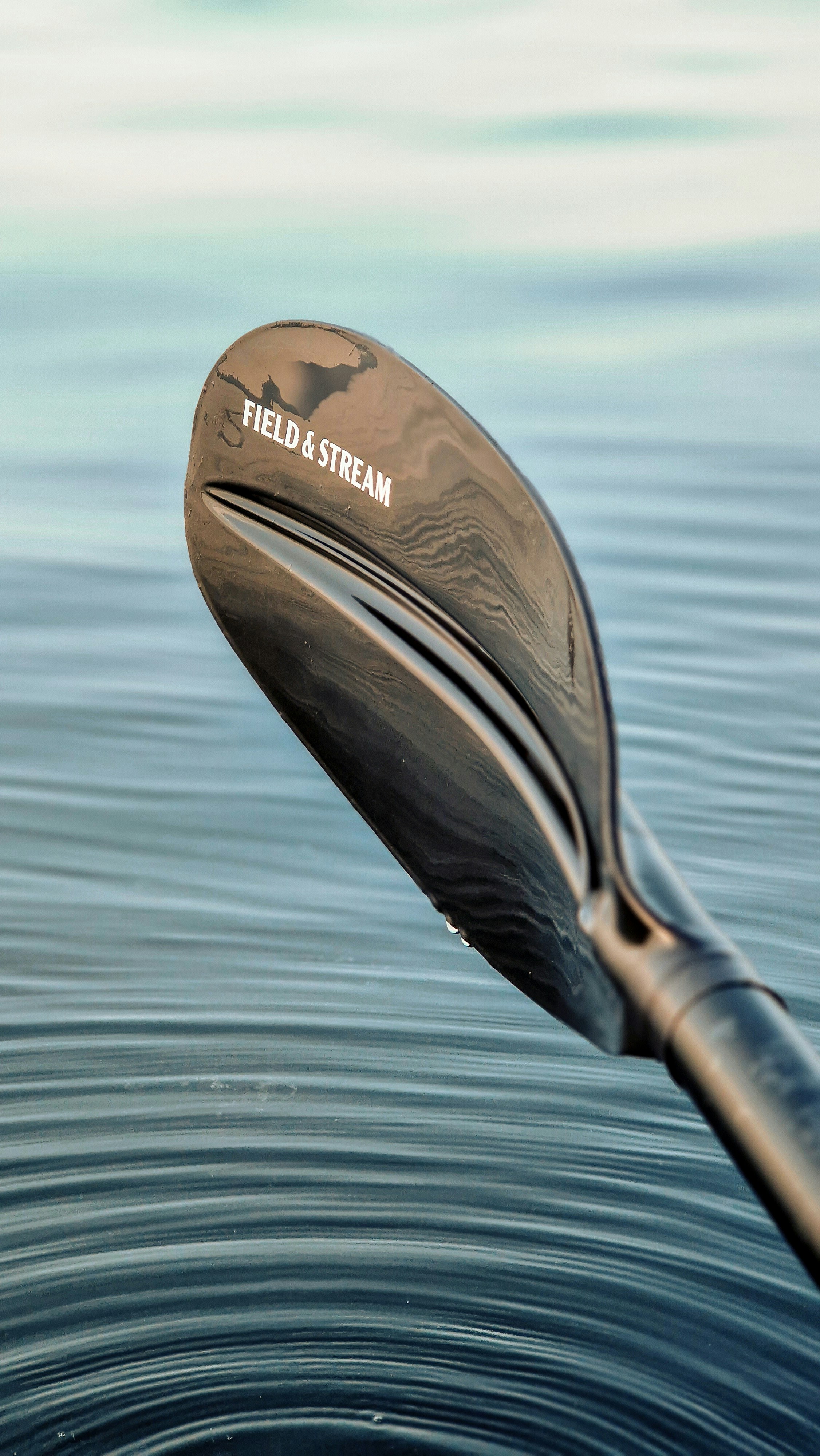 Oar gliding over ripples: Field & Stream blade in focus