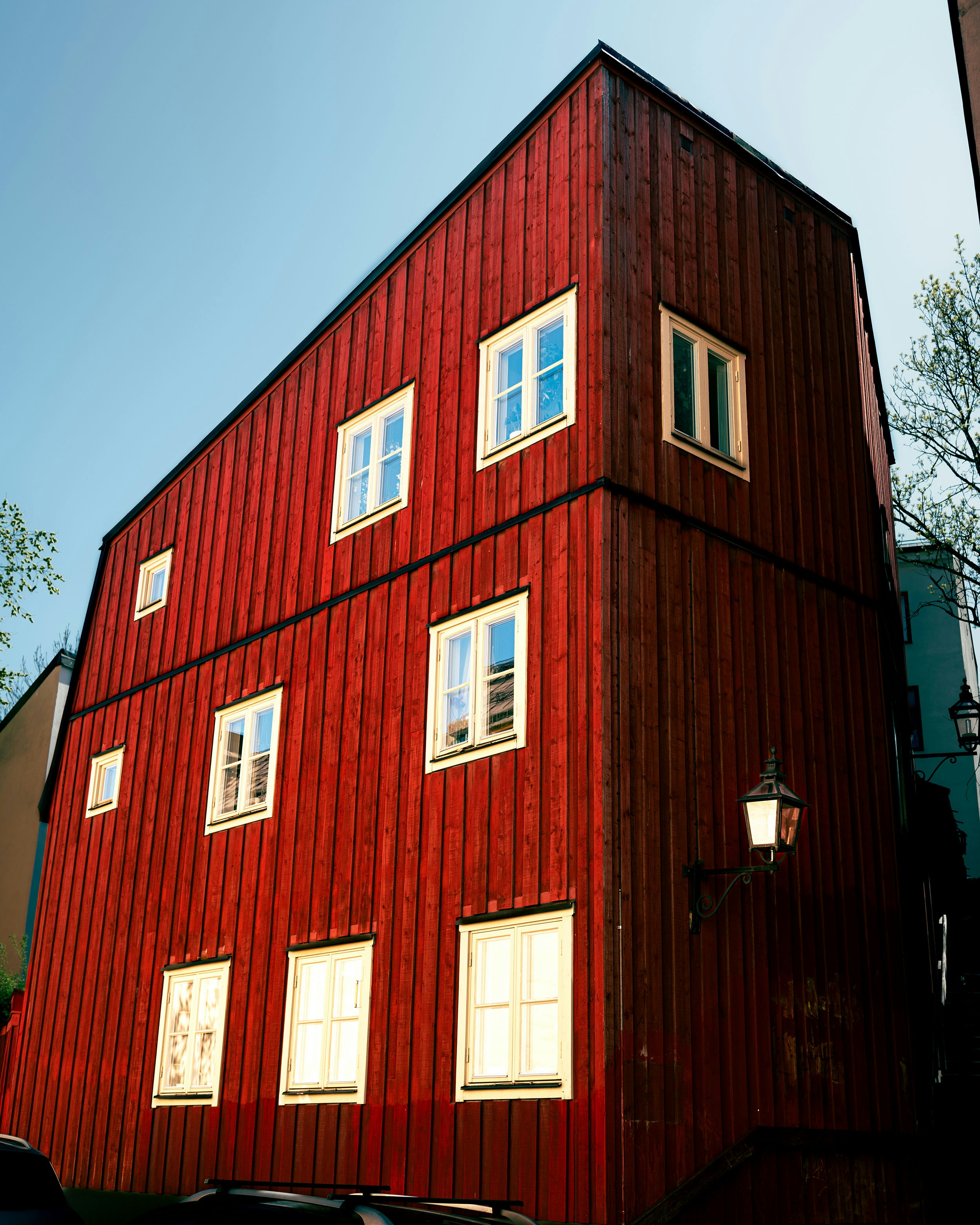 A tall red building with three windows on the side of it photo – Free ...