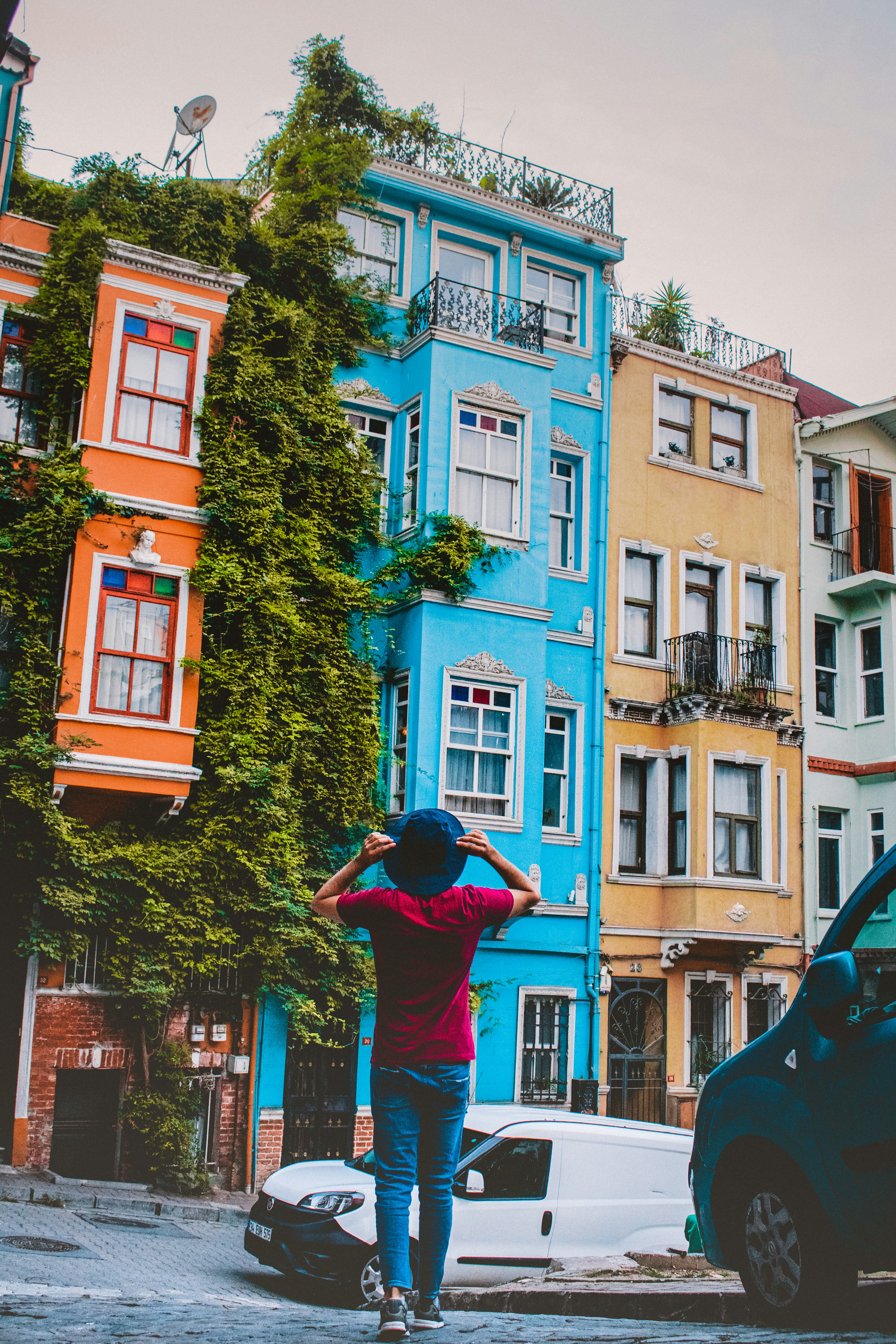 a person standing in front of a row of multicolored buildings