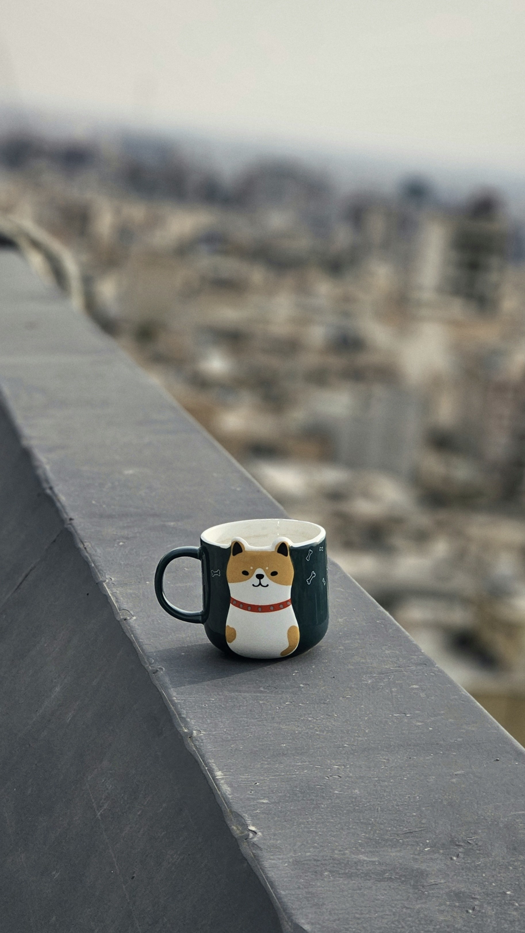Tiny Shiba Mug on a Rooftop Rail Amid a City Blur