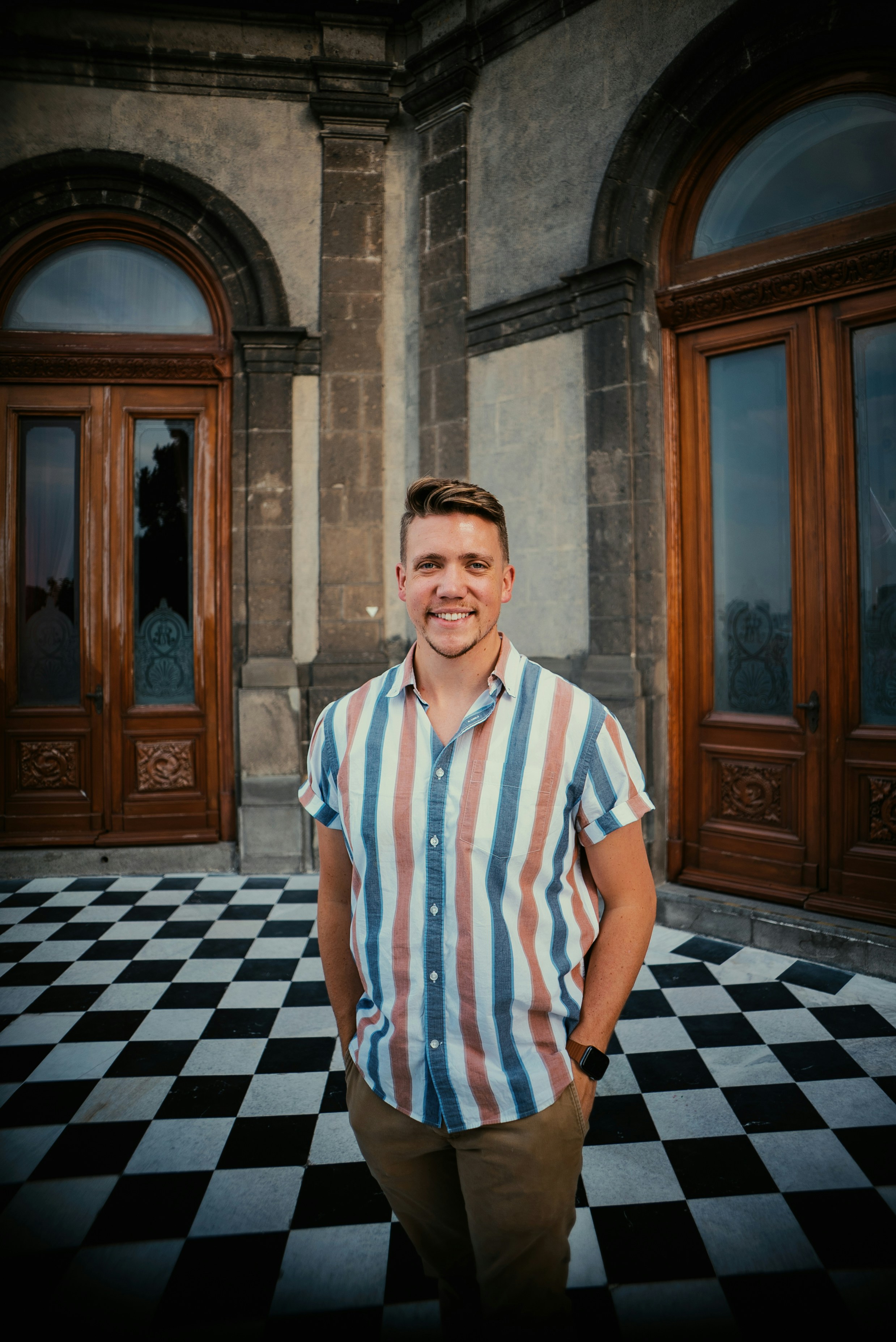 Portrait on a Checkered Threshold: Stripes, Stone, and a Friendly Smile