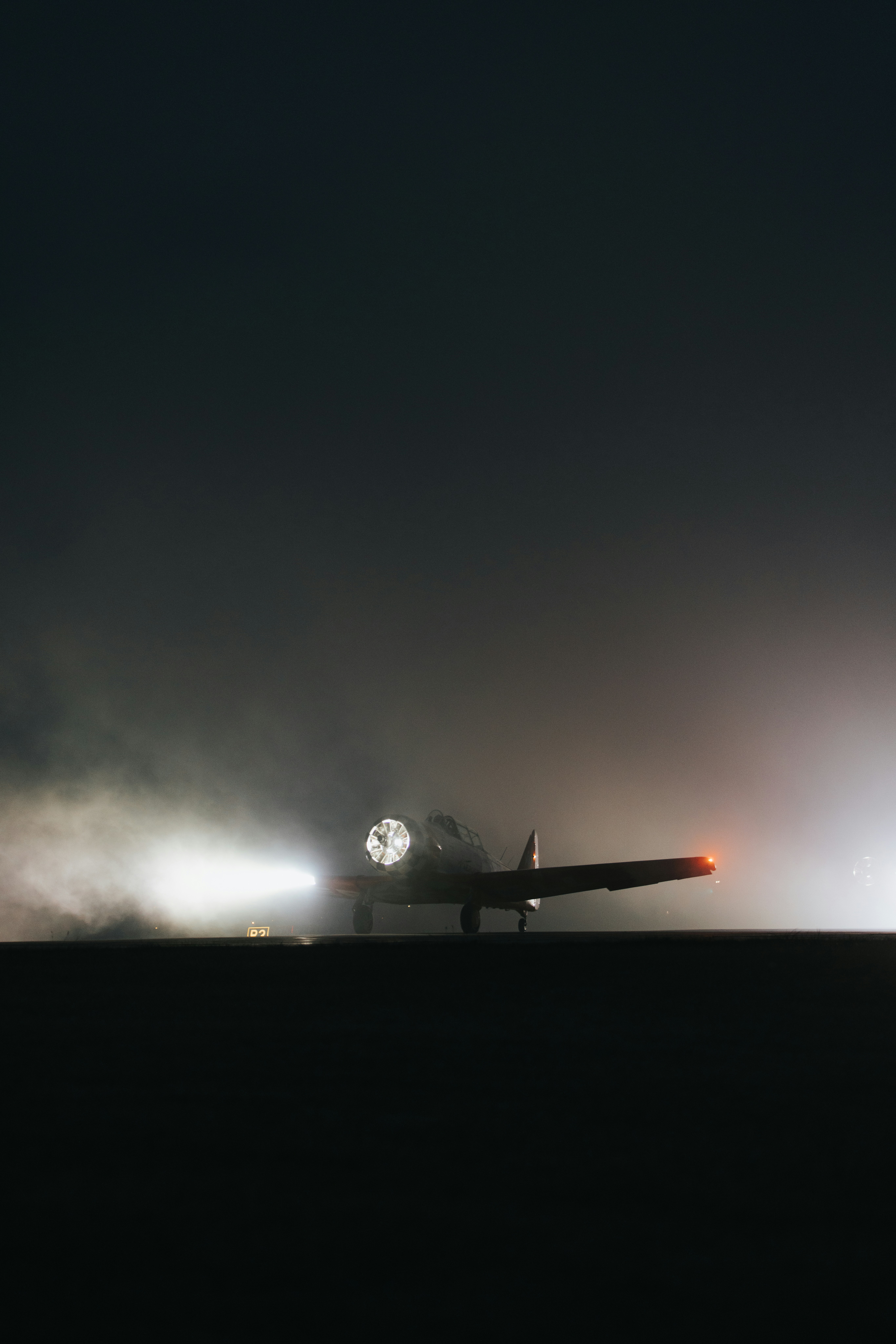 Night Vigil on the Runway: A Lone Aircraft Emerges from Fog