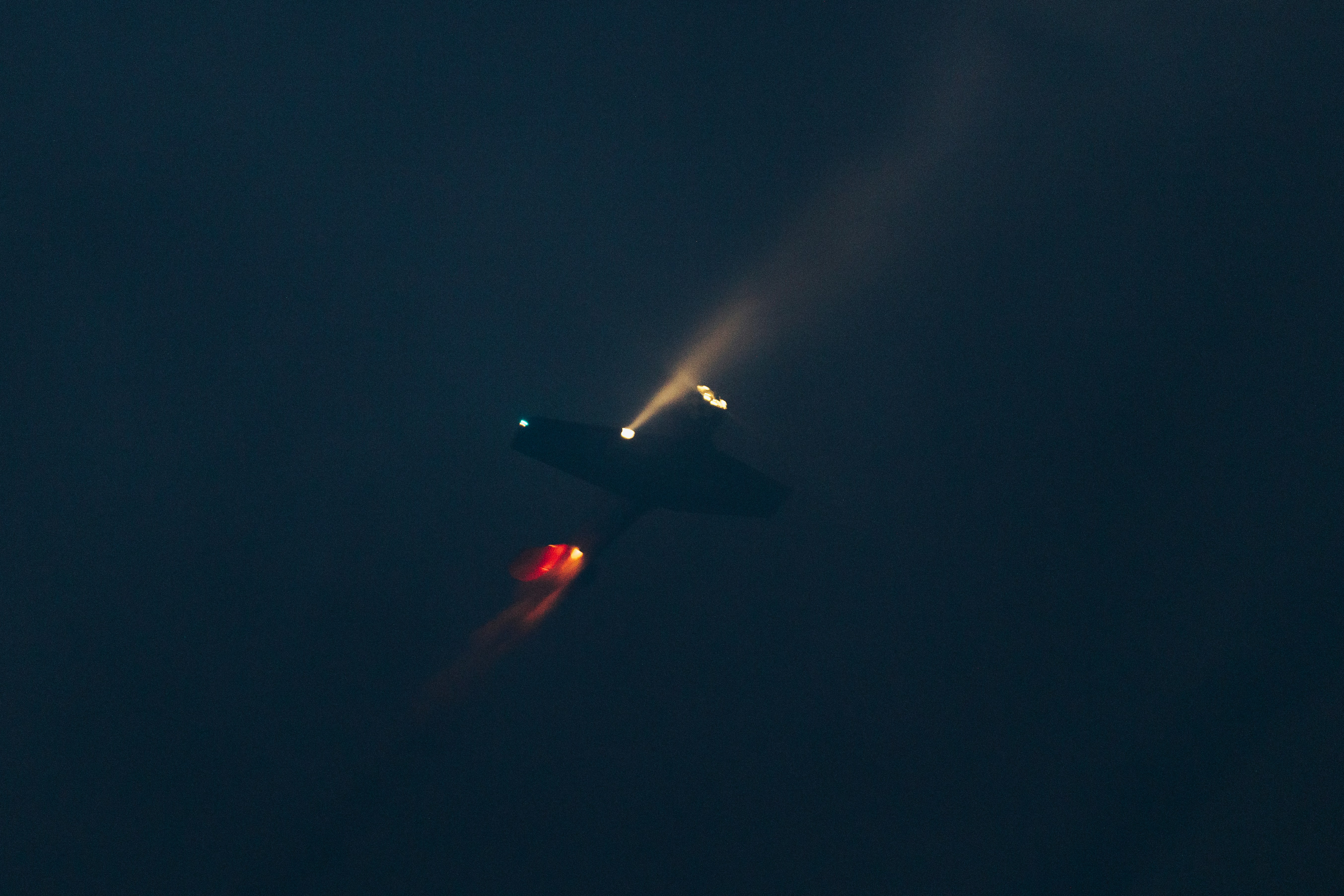 Nocturnal Beacon: A distant aircraft carves a light trail through a velvet night sky.