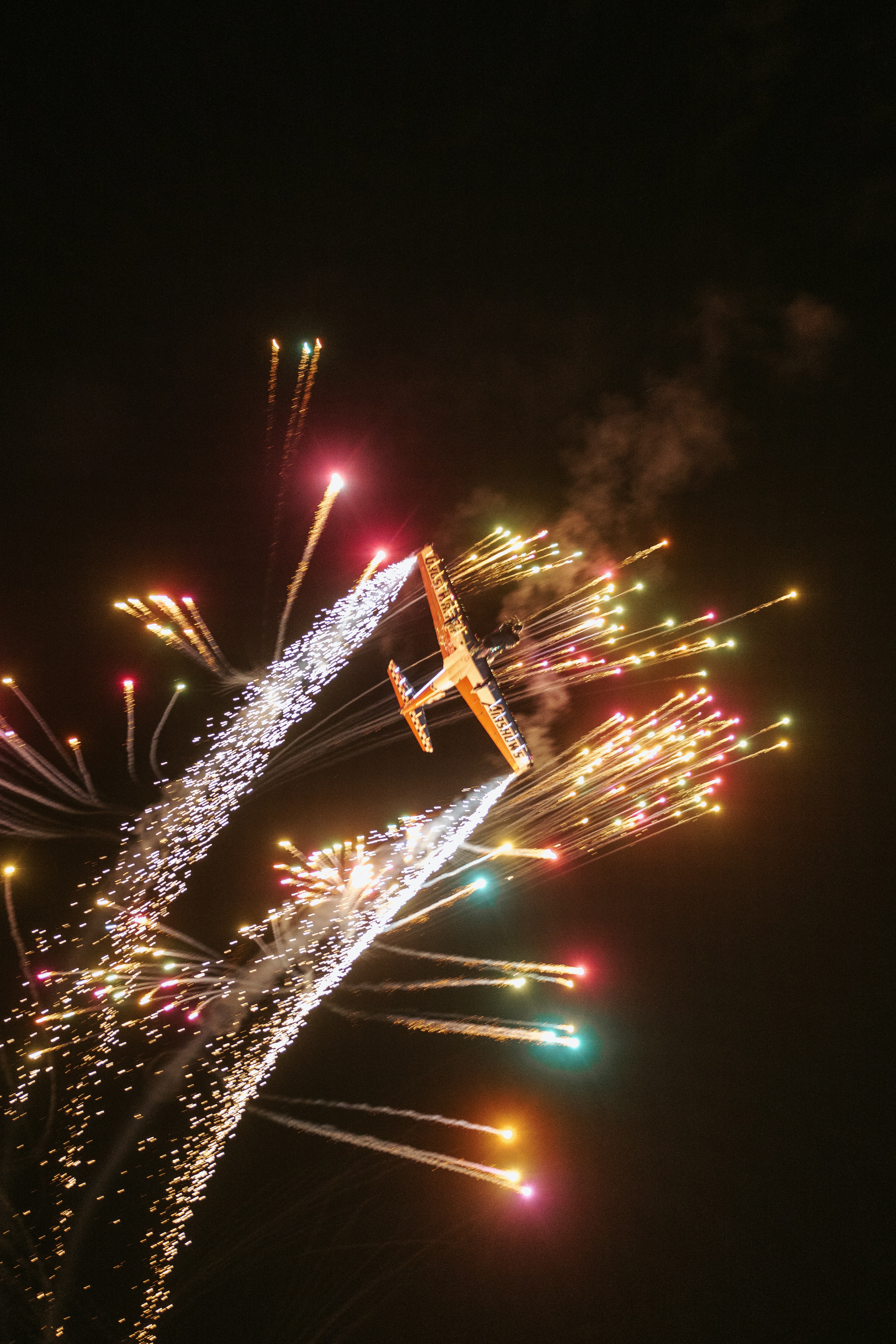 A plane is flying in the sky with a lot of fireworks photo – Free ...