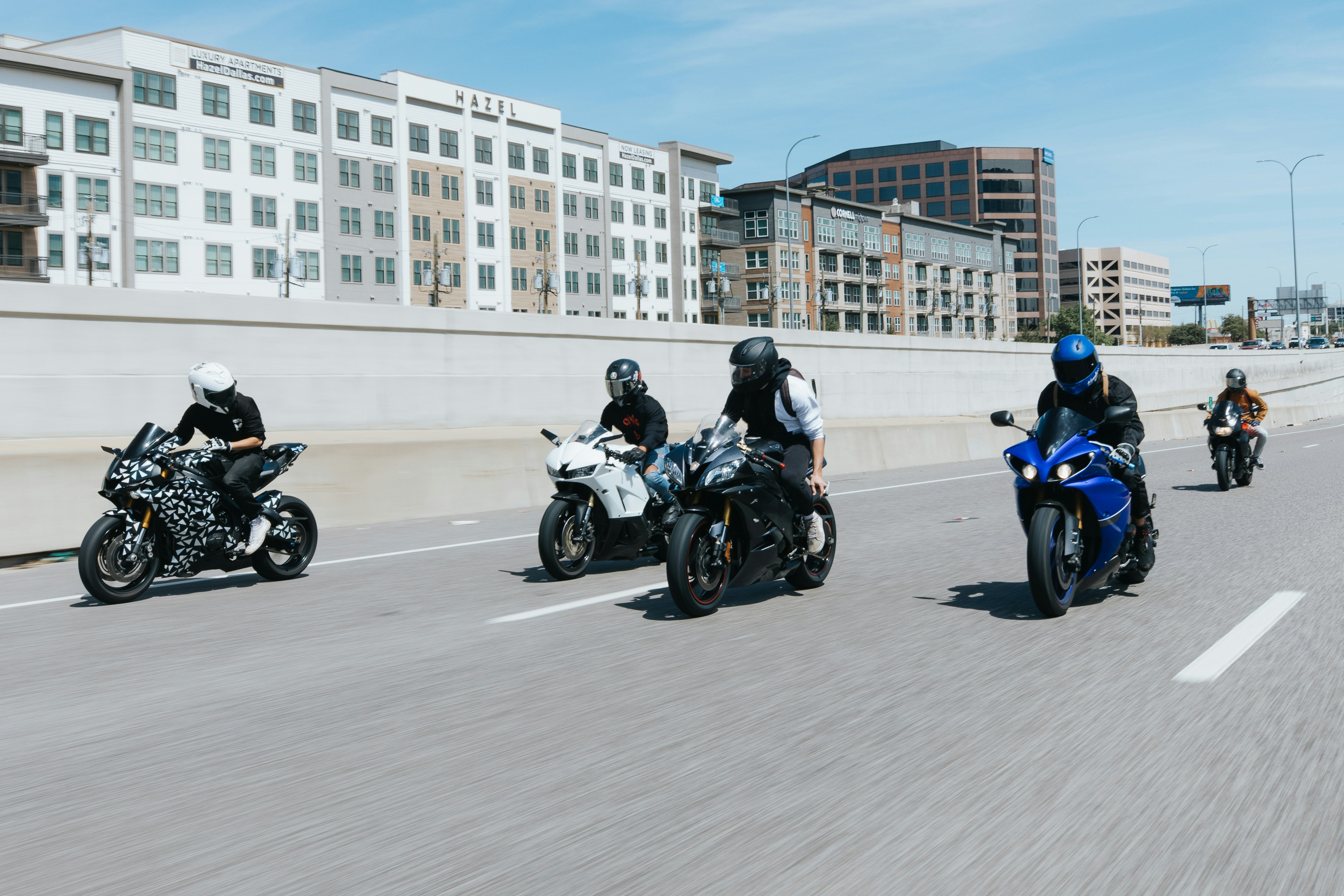 A group of people riding motorcycles down a street photo – Free Grey ...