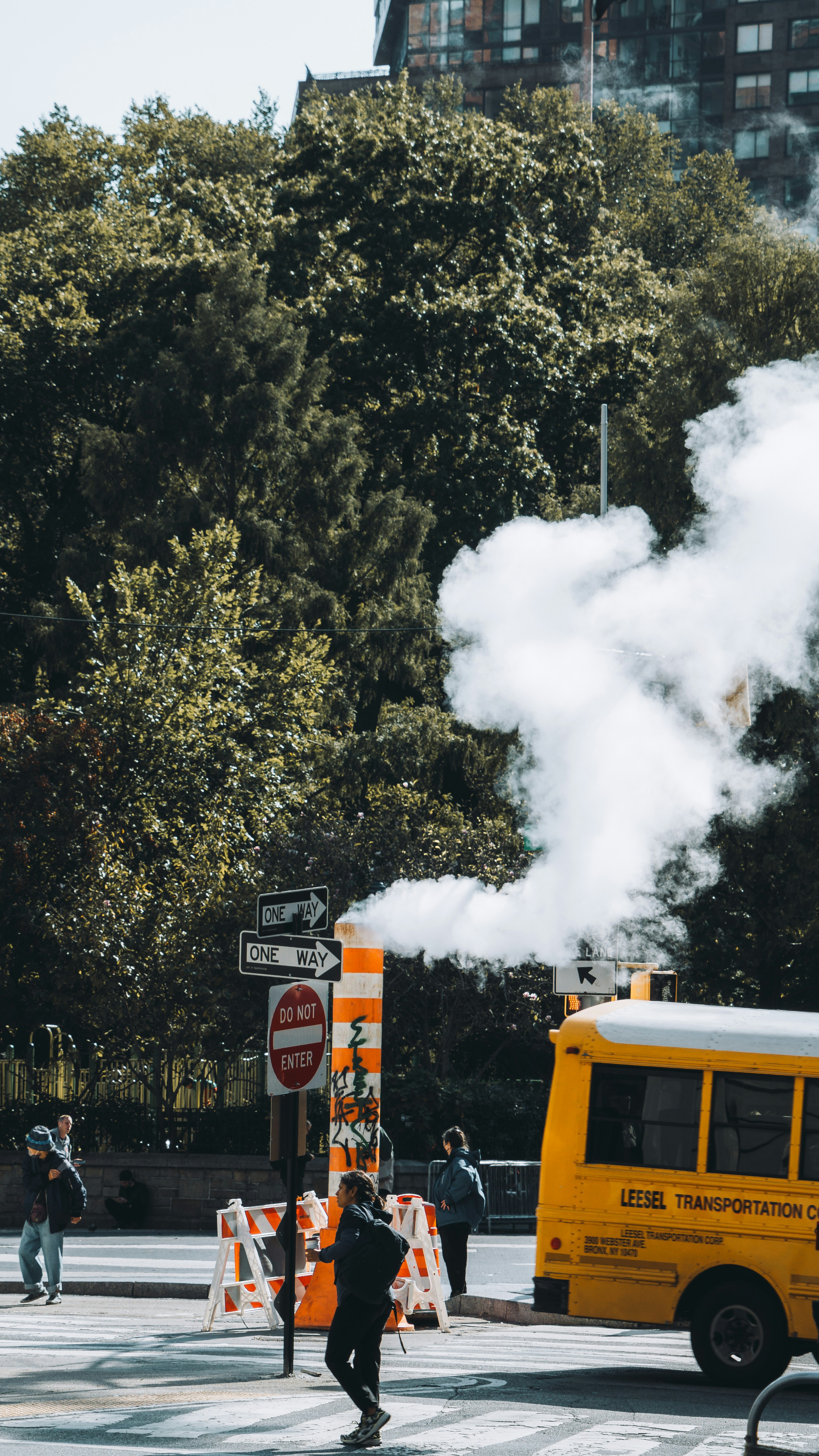 Steam Wisp Over a City Intersection: Bus, Barriers, and City Pulse