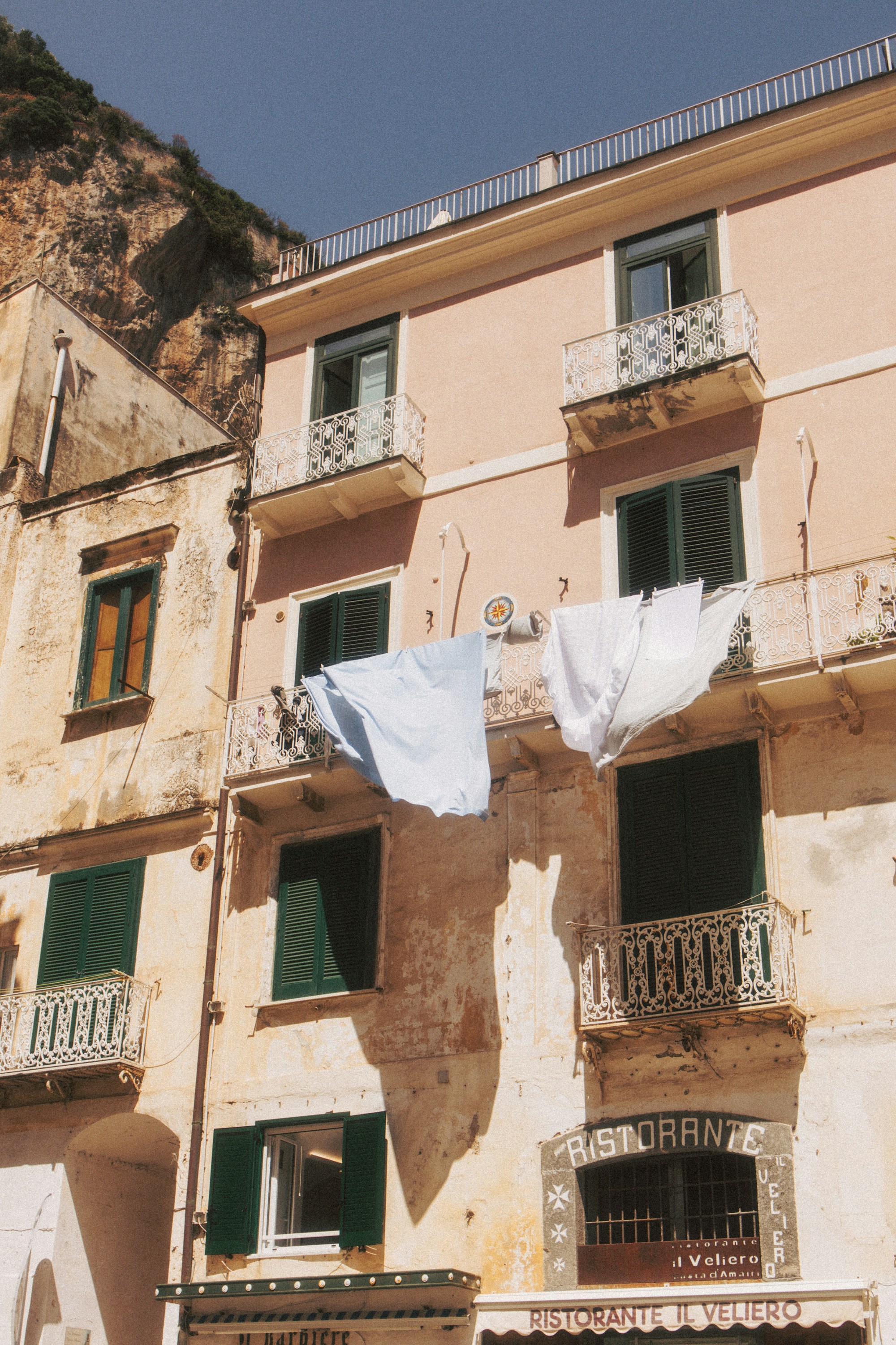 White Laundry Drapes Across a Weathered Mediterranean Façade