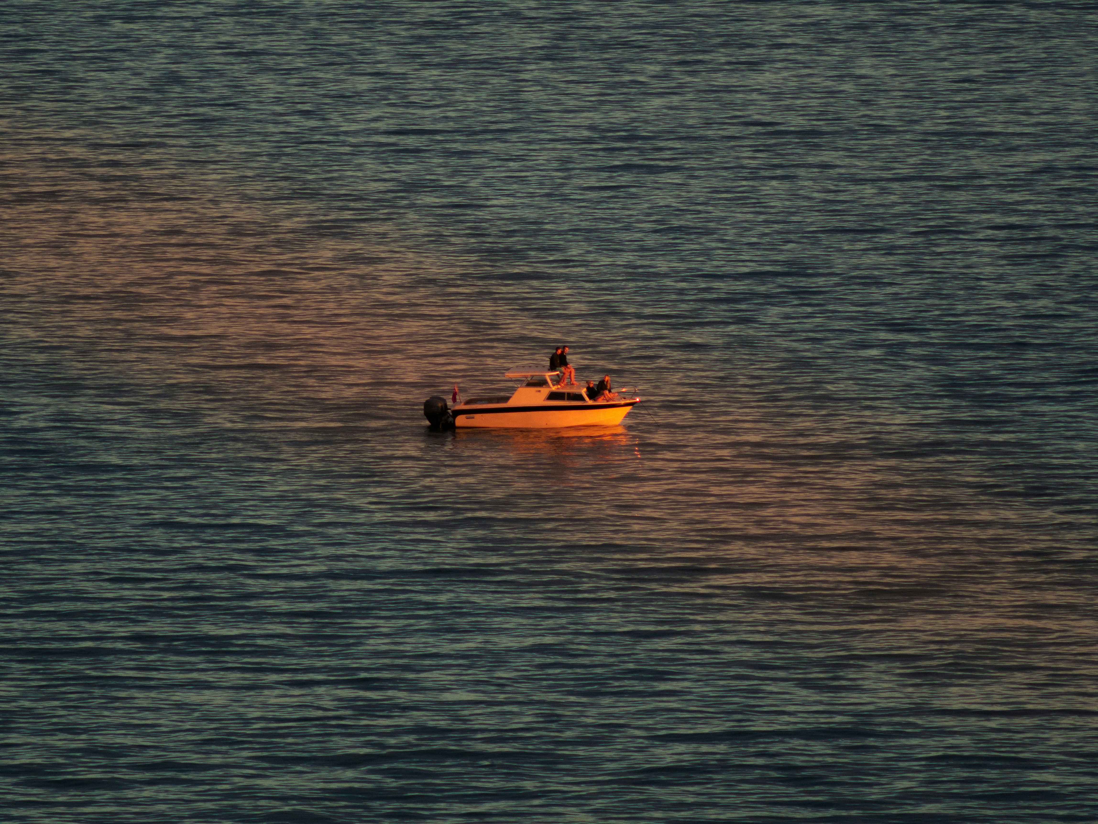 A small yellow boat floating on top of a body of water photo – Free ...