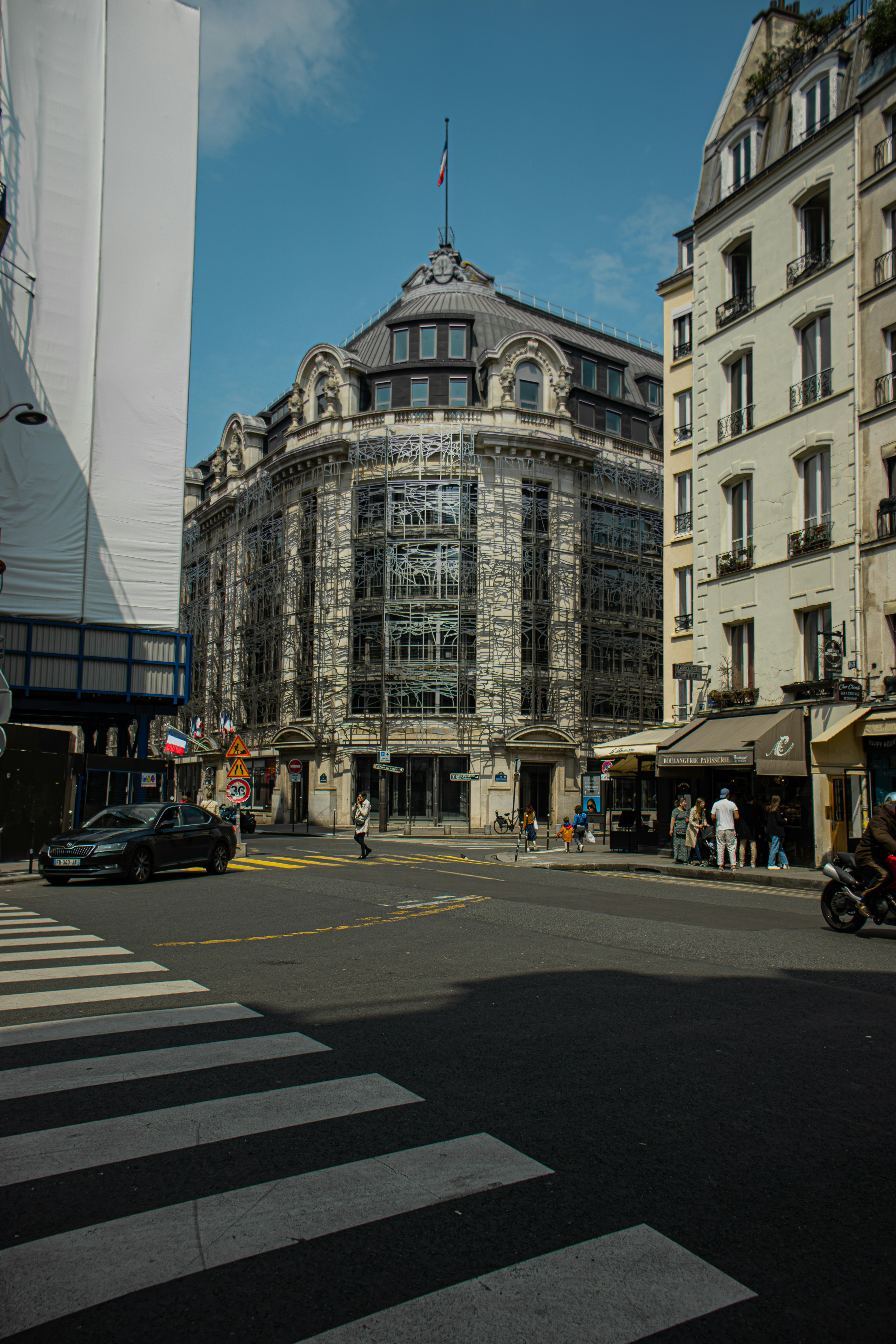 A large building sitting on the corner of a street photo – Free Paris ...
