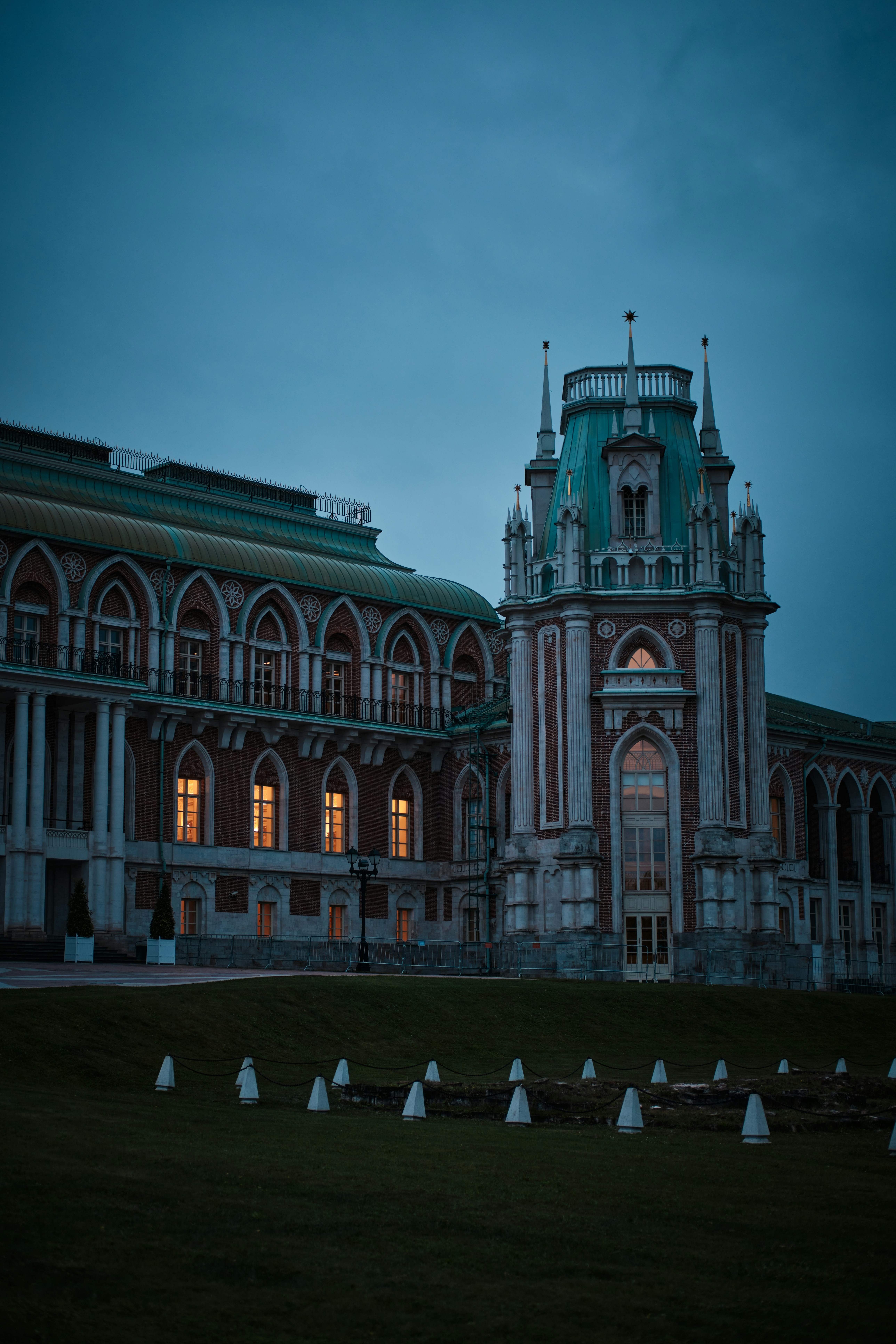 Moonlit Neo-Gothic Facade: Tower and Arched Hall Under Evening Sky