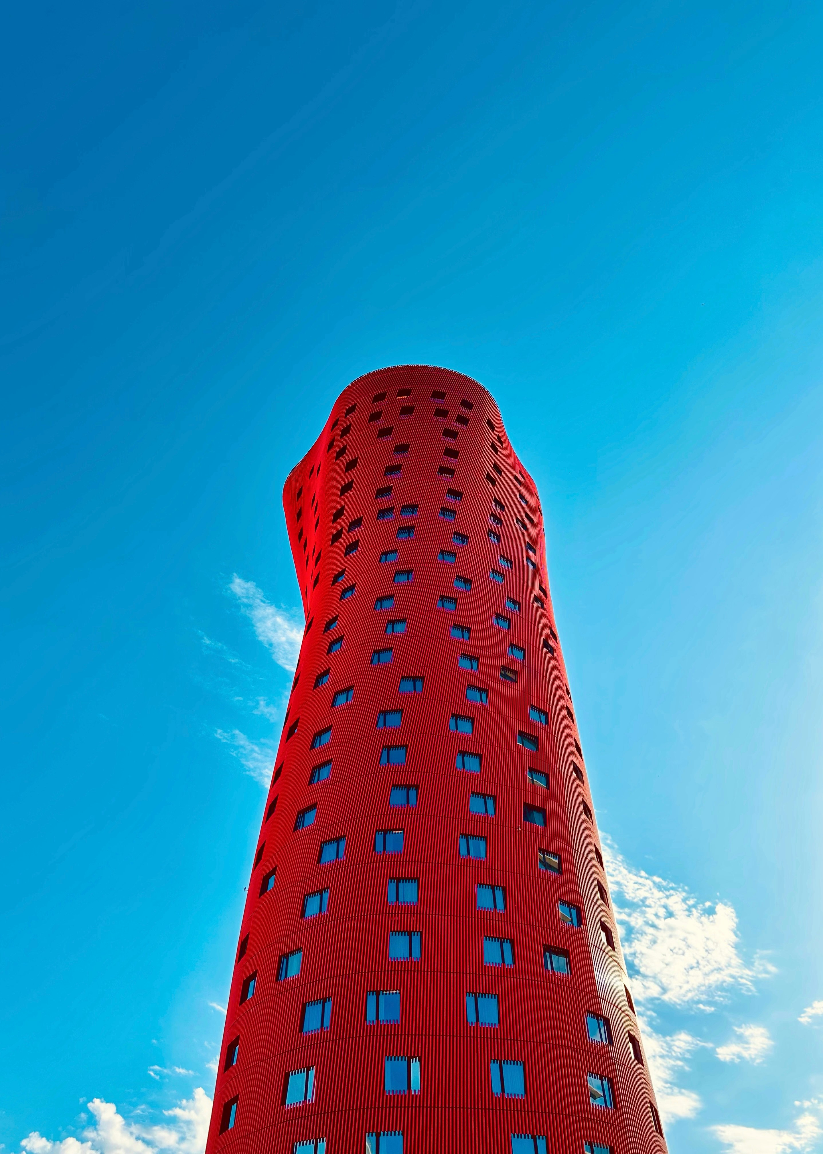 A tall red building with windows on the side of it photo – Free Tower ...