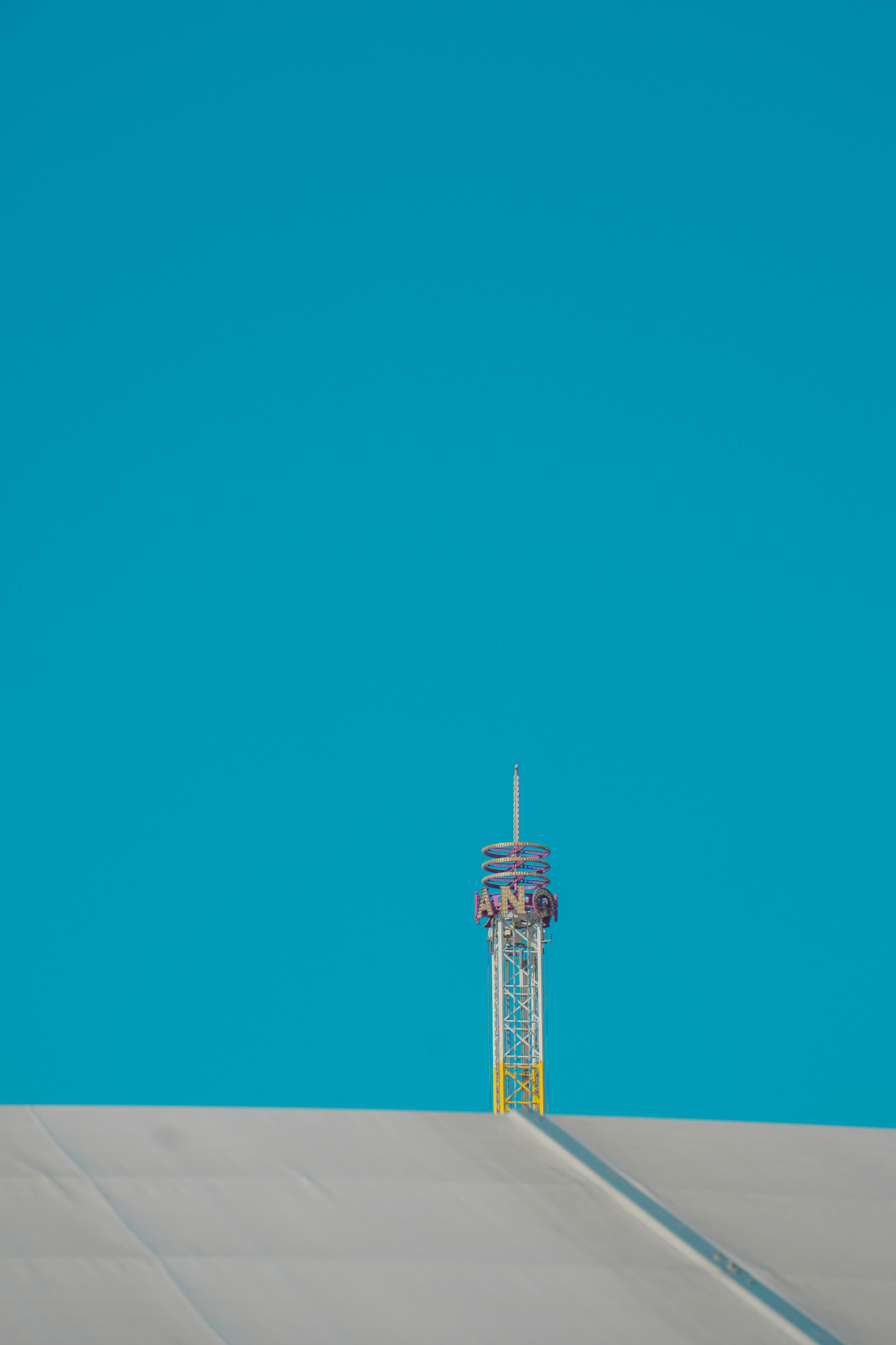 Antenna Tower Peeking Over a Minimal Ridge Under a Cerulean Sky