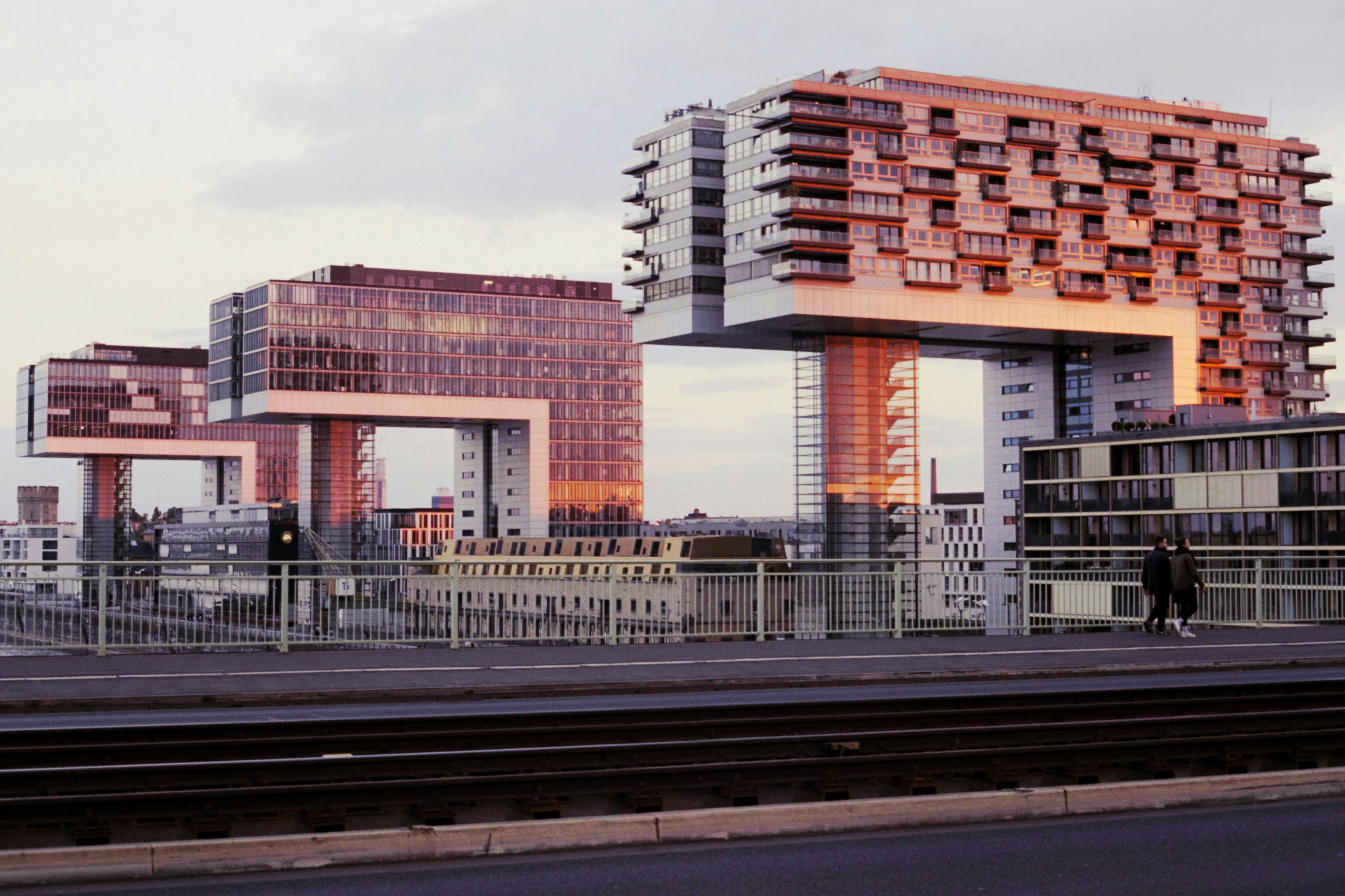 Modern architectural structures, known as Crane Towers, illuminated by a warm sunset glow.