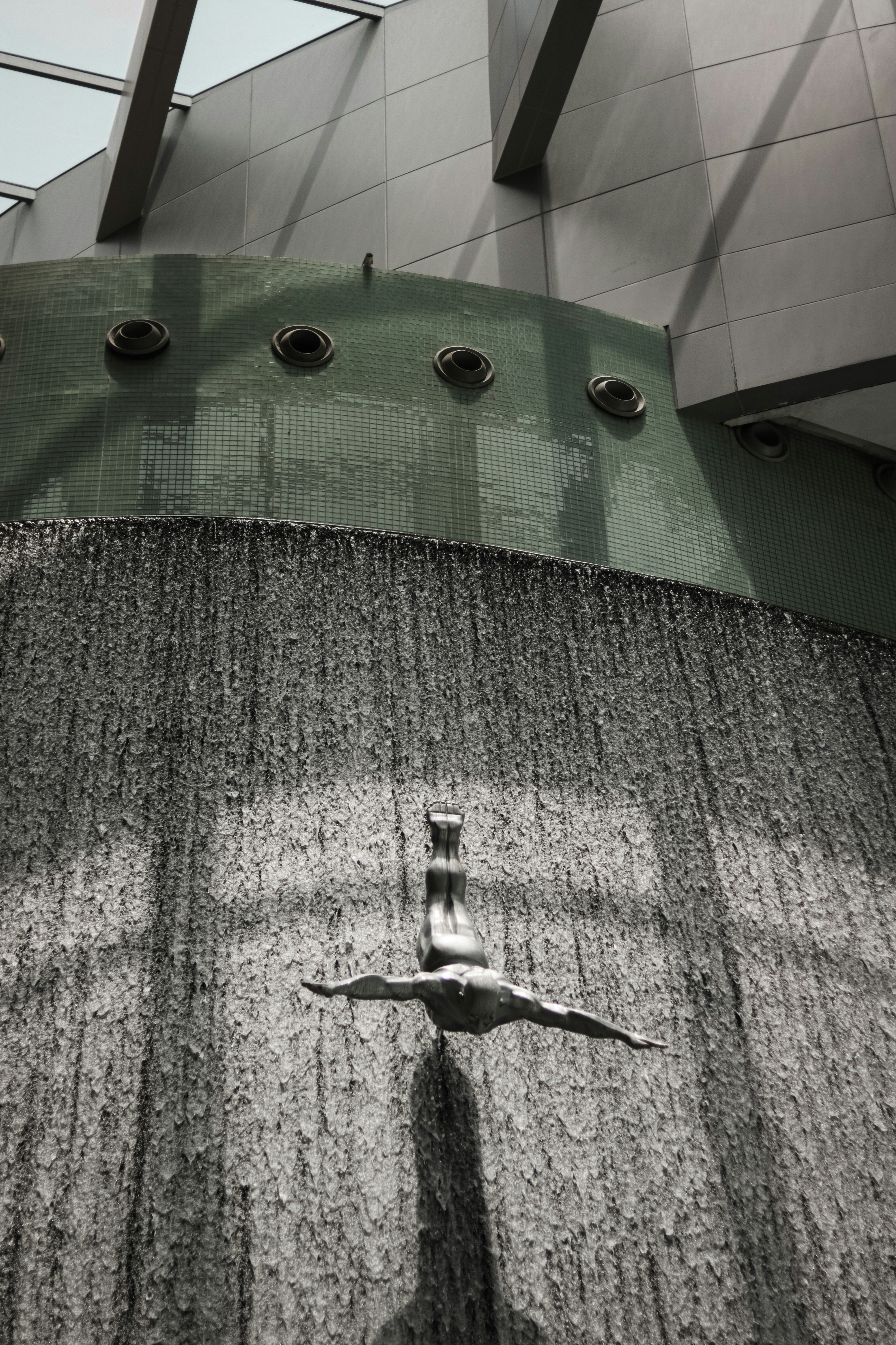 Diver in Flight: A Sculpted Splash Against Modern Architecture