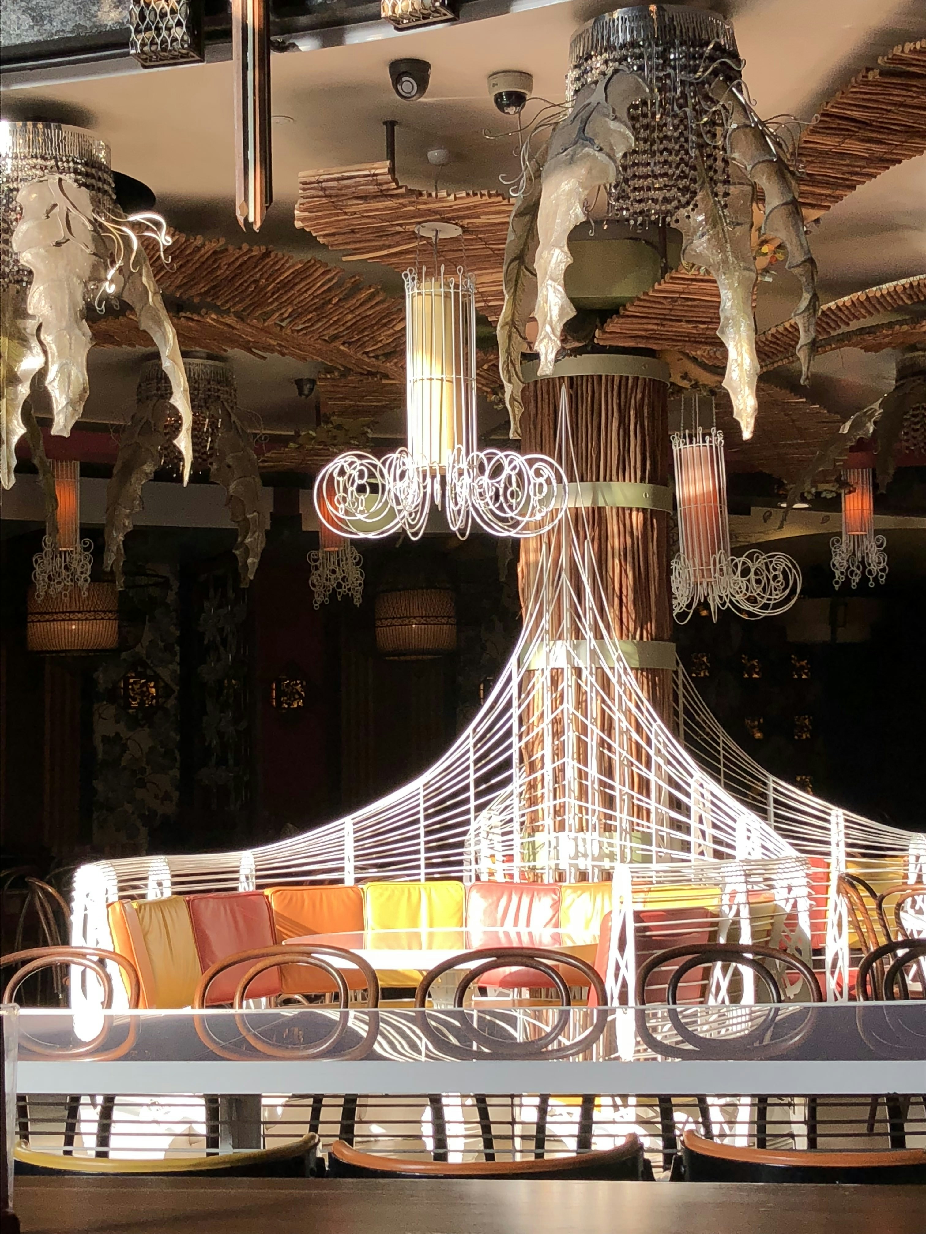 Luminous Loops Over a Colorful Lounge: Neon Chandelier in Warm Glow