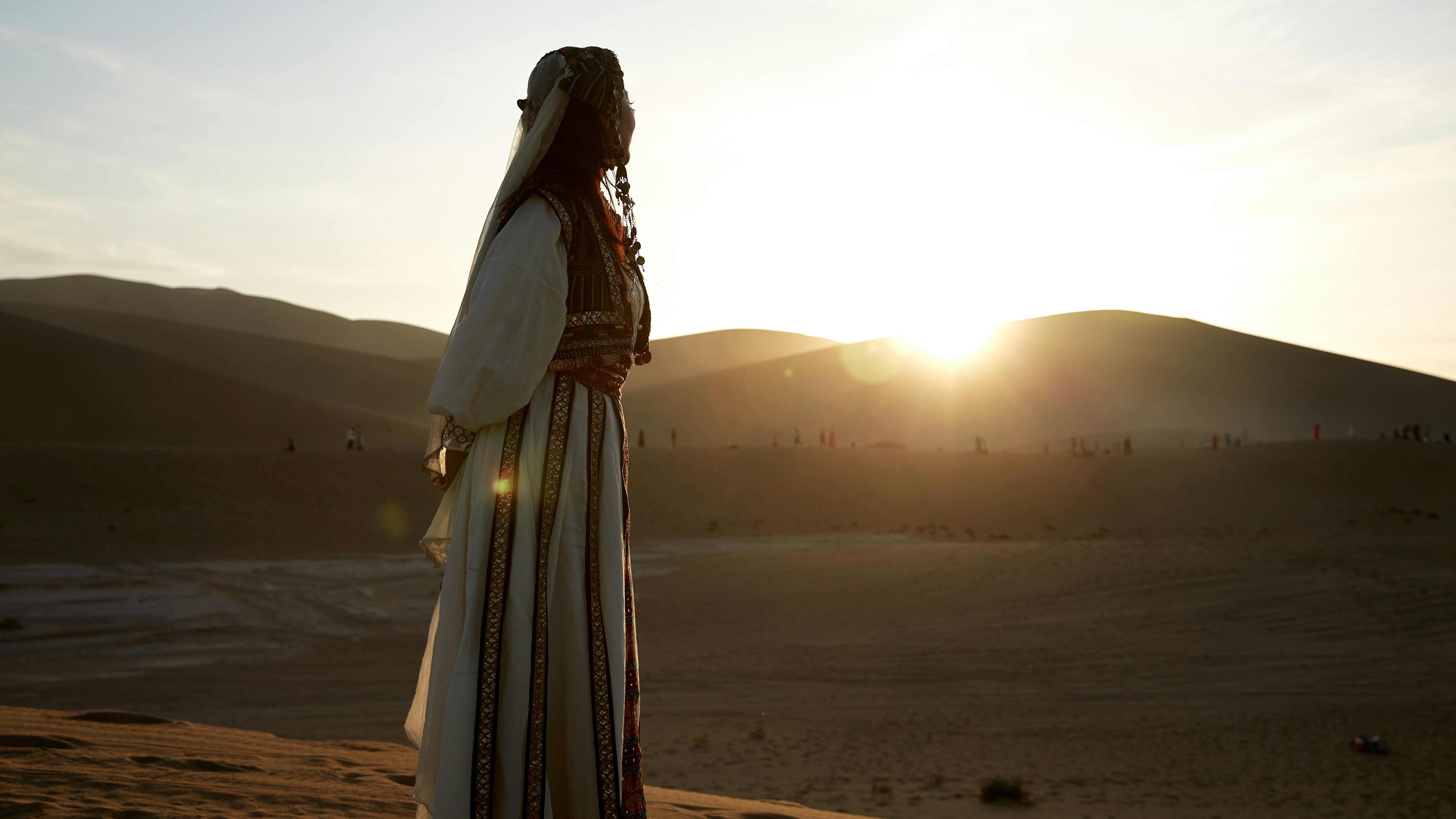 Dawn Veil in the Dunes: A solitary figure in regal desert attire