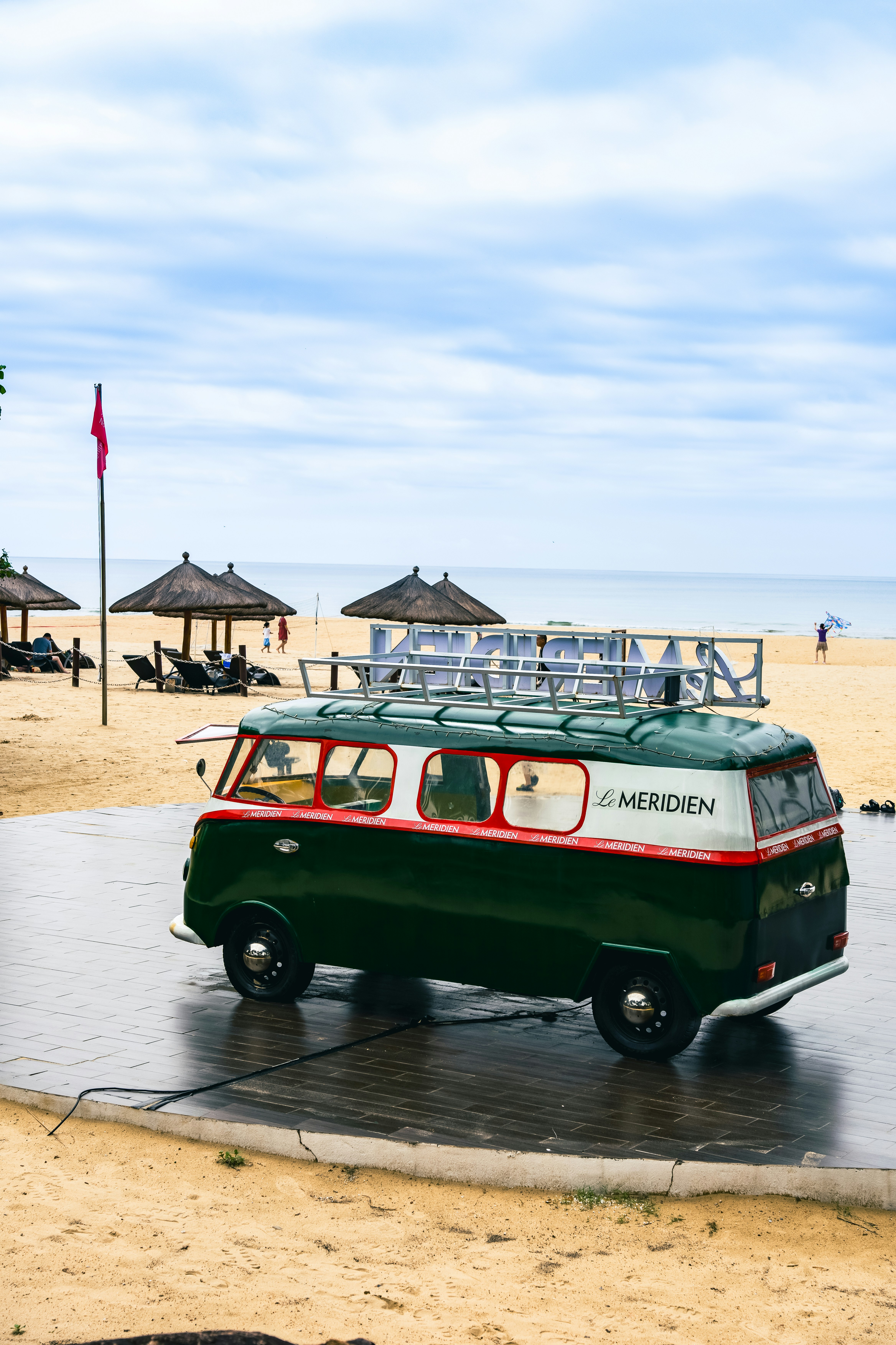 Green Sea-Glider Van Anchored on a Sunny Beach