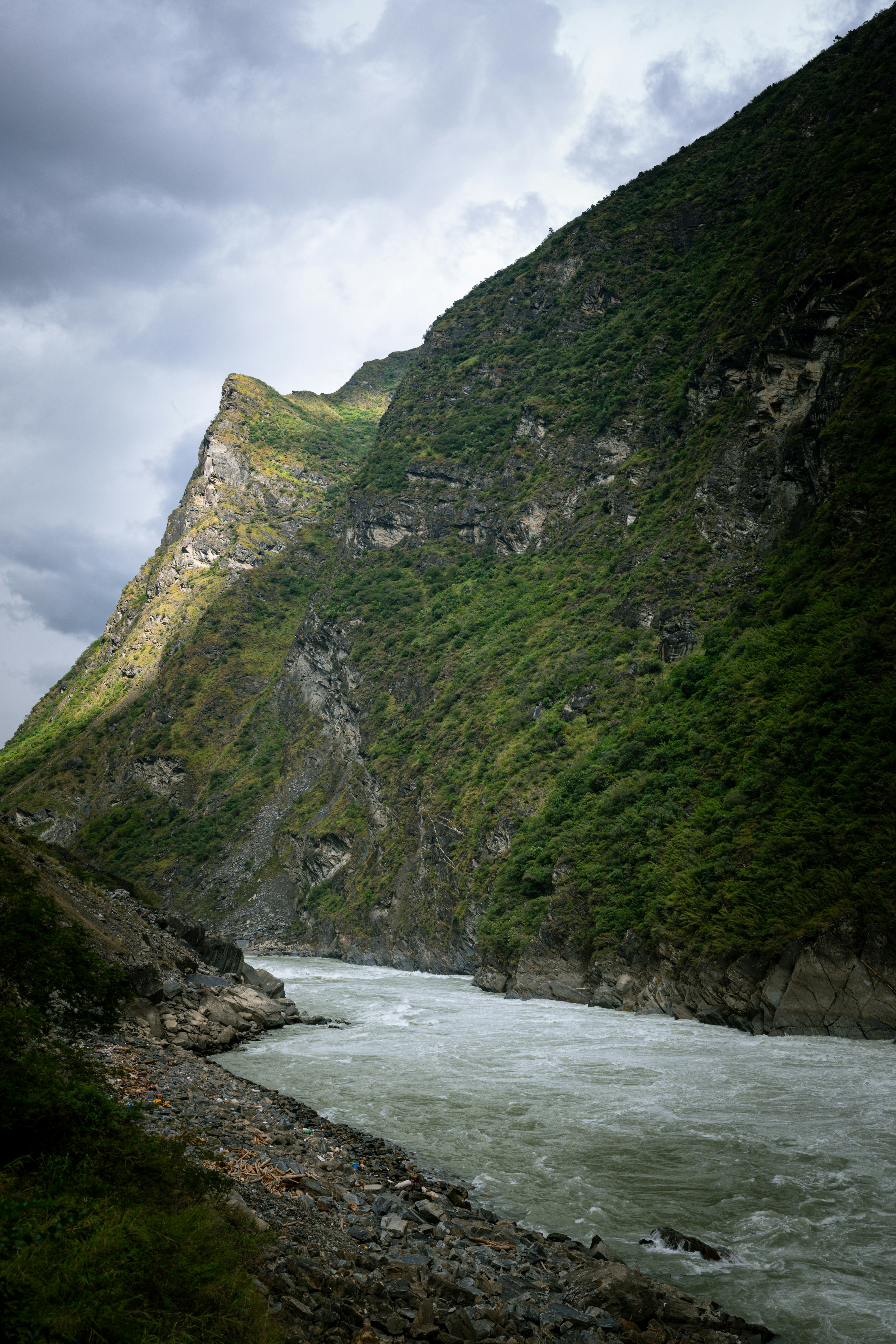 Sunlit Crest Over a Turbulent Gorge: River Carves Green Walls