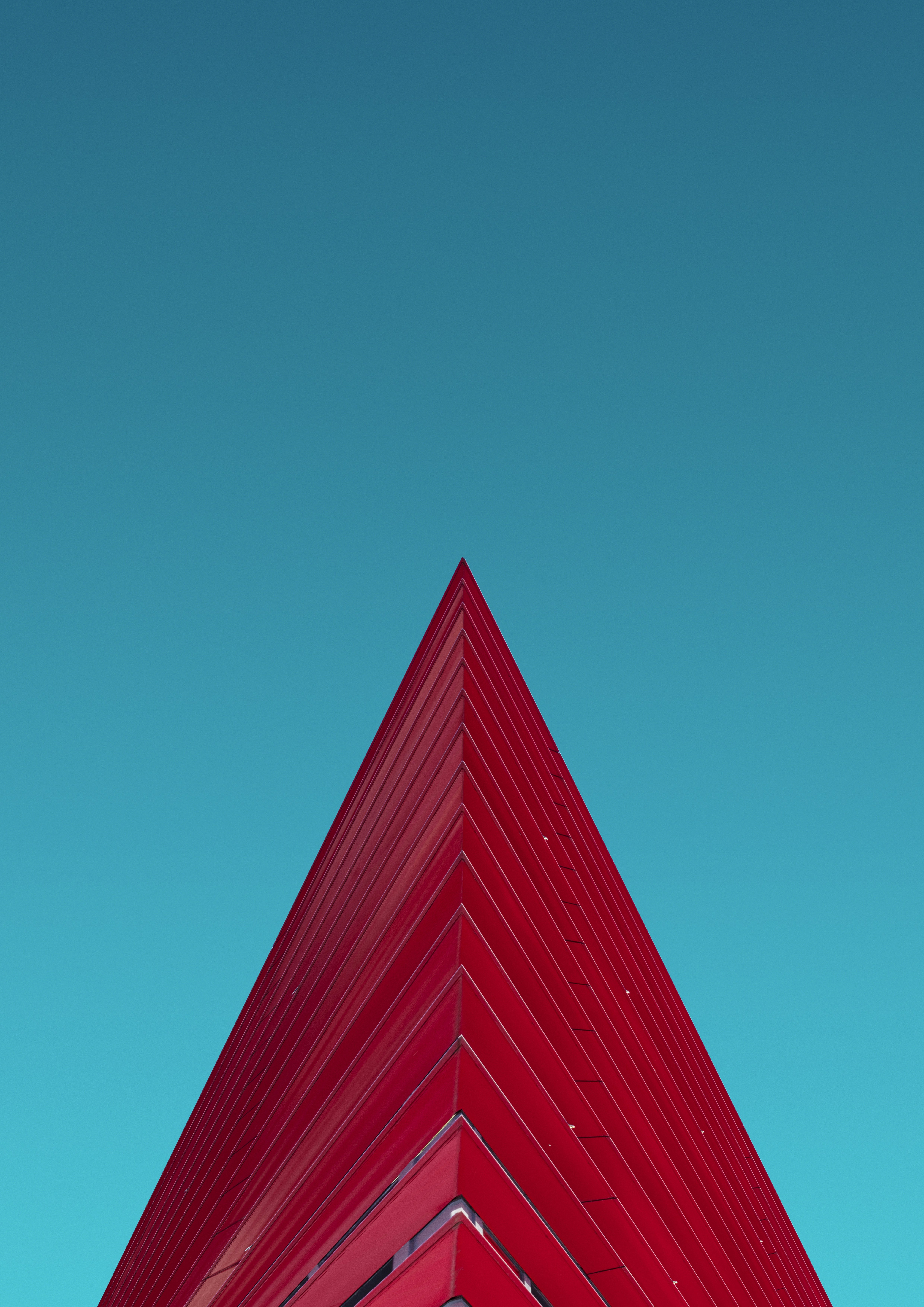 A red triangular shaped building against a blue sky photo – Free ...