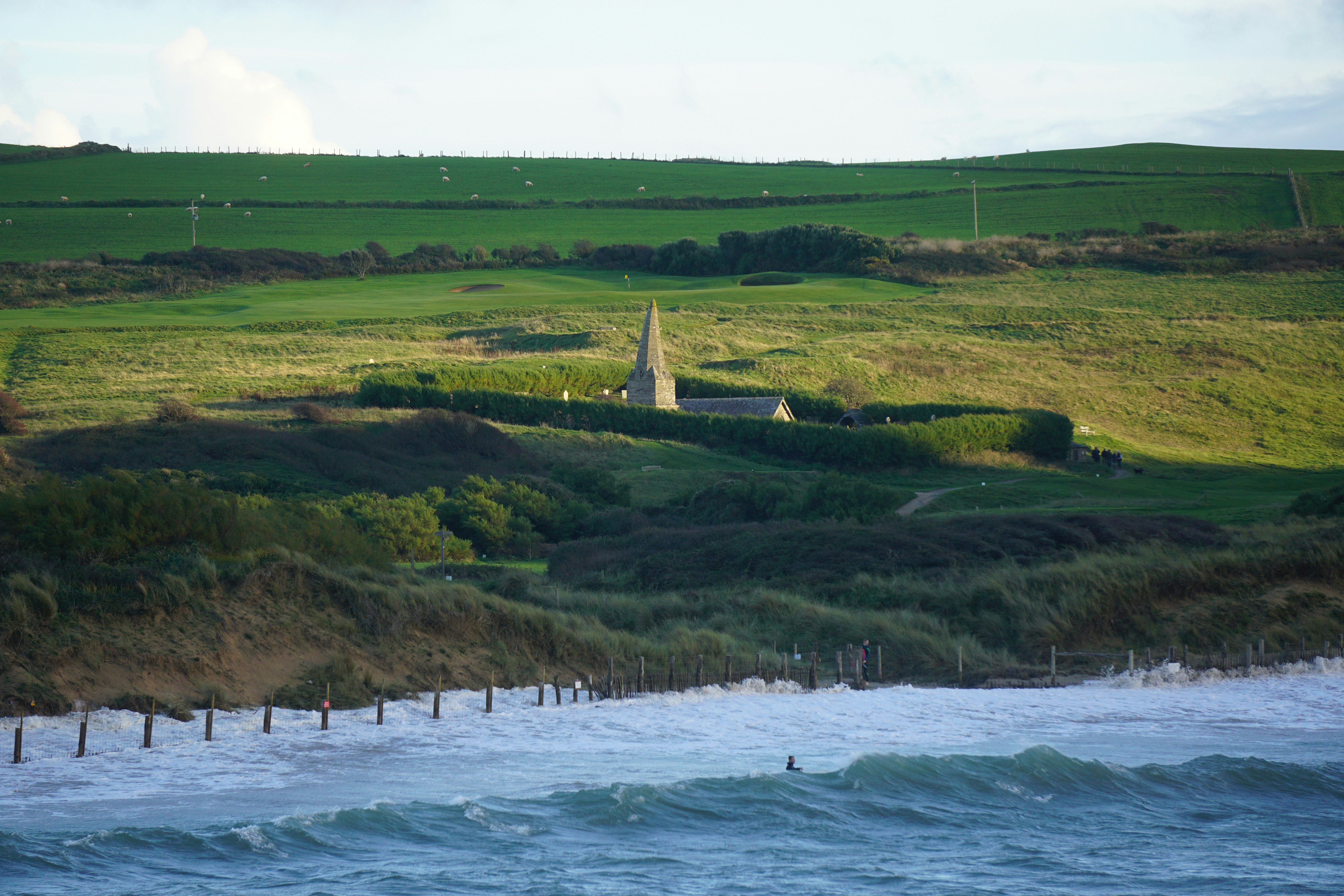 Coastal Green Slope with a Distant Chapel Silhouette