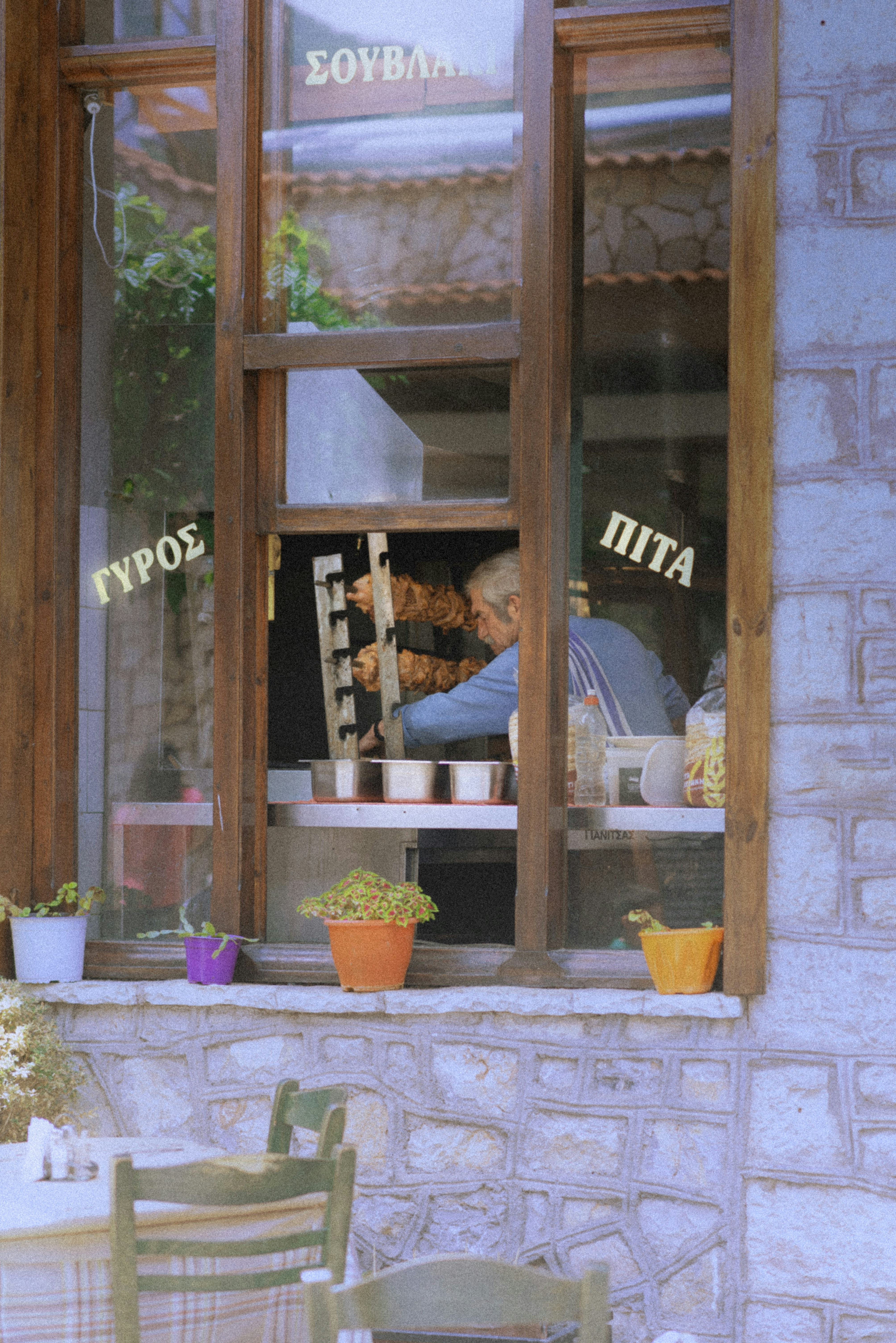 Framed Flame: Gyros Sizzle Behind a Windowed Kitchen