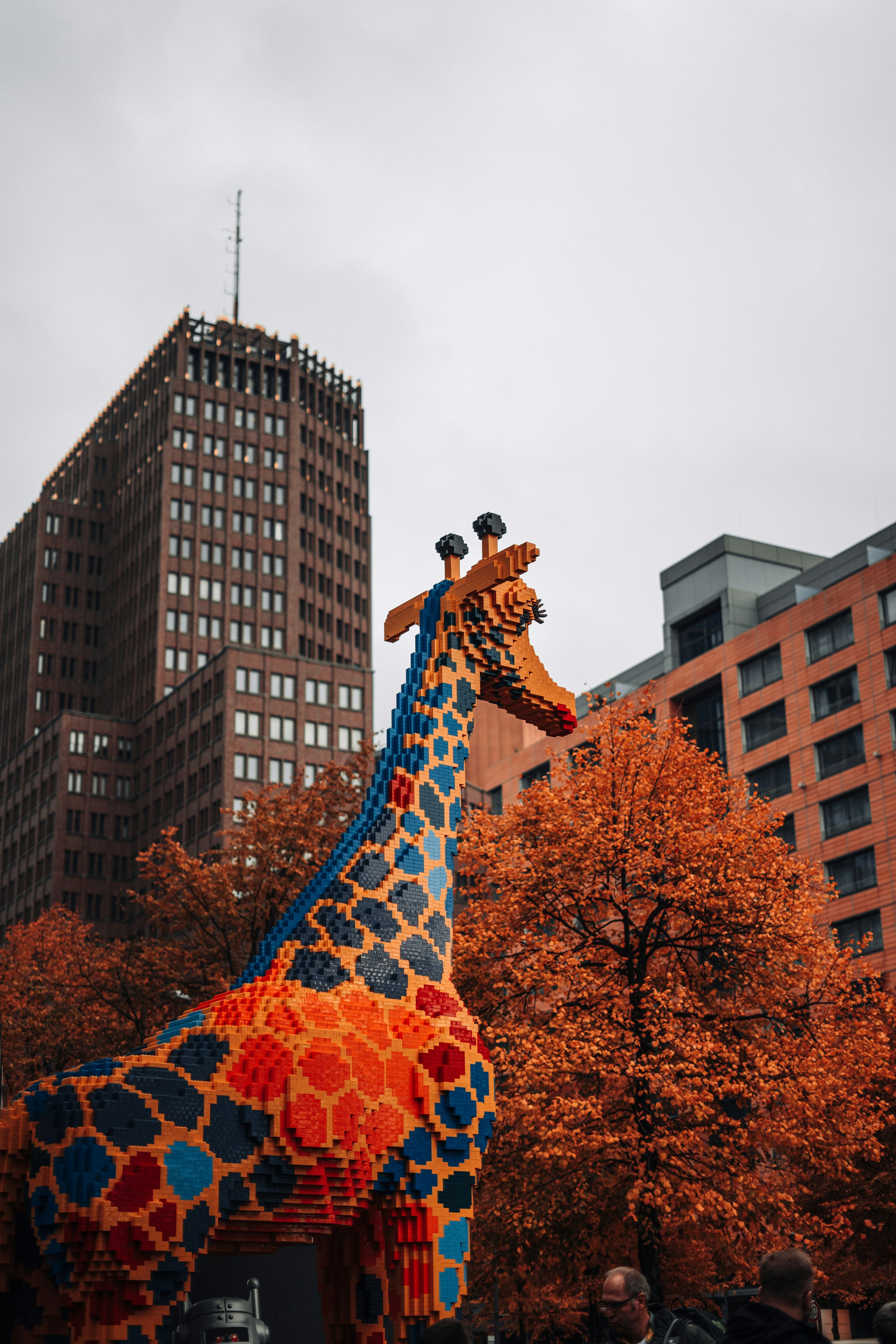 Brick-Giraffe in the Autumn City: Colorful Giants Amid Skyscrapers
