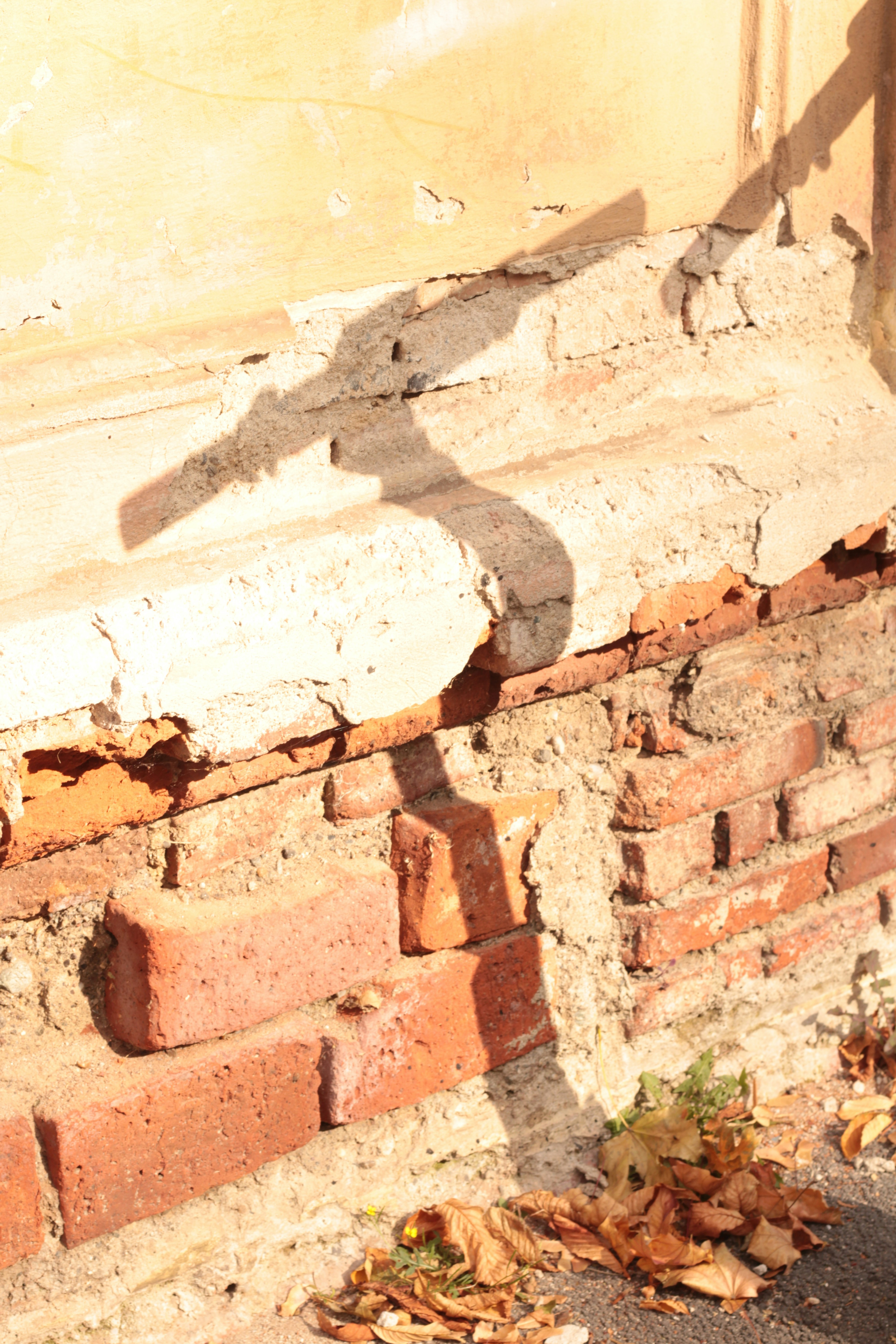 Shadow of a Window Sill Cast Across Weathered Brick