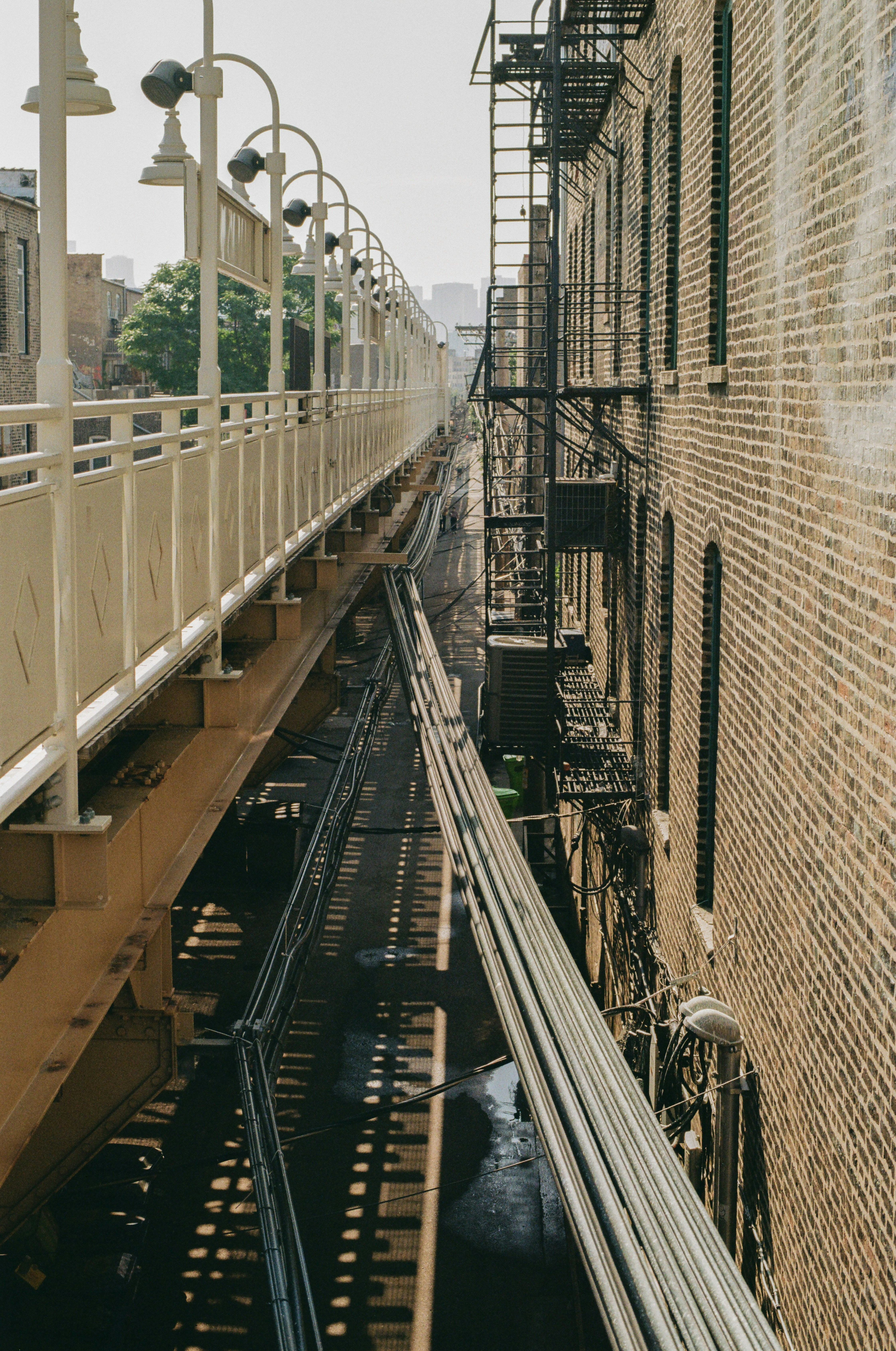 A train traveling down tracks next to a tall brick building photo ...