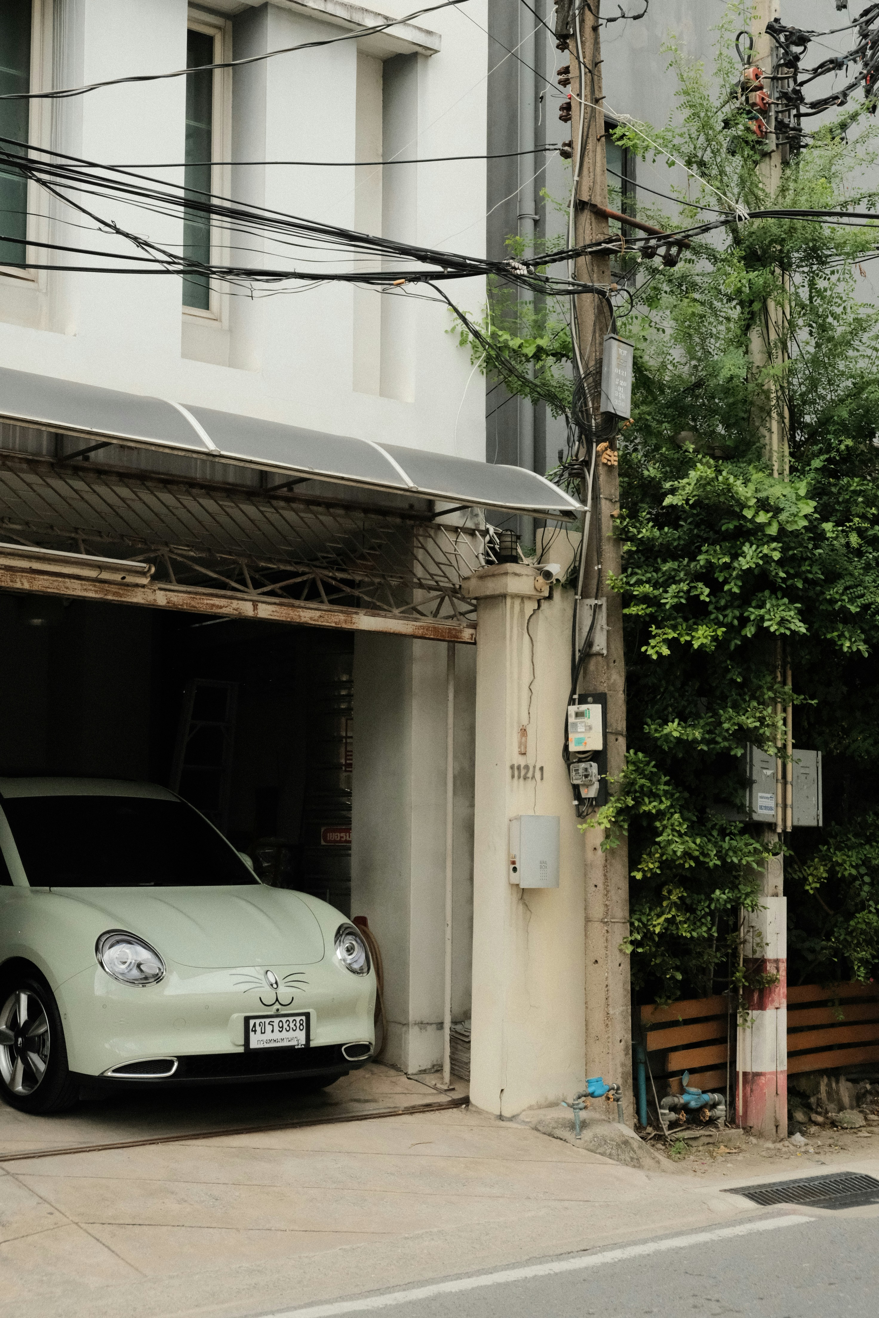 Pastel Sedan in a Narrow Urban Garage under a Web of Cables