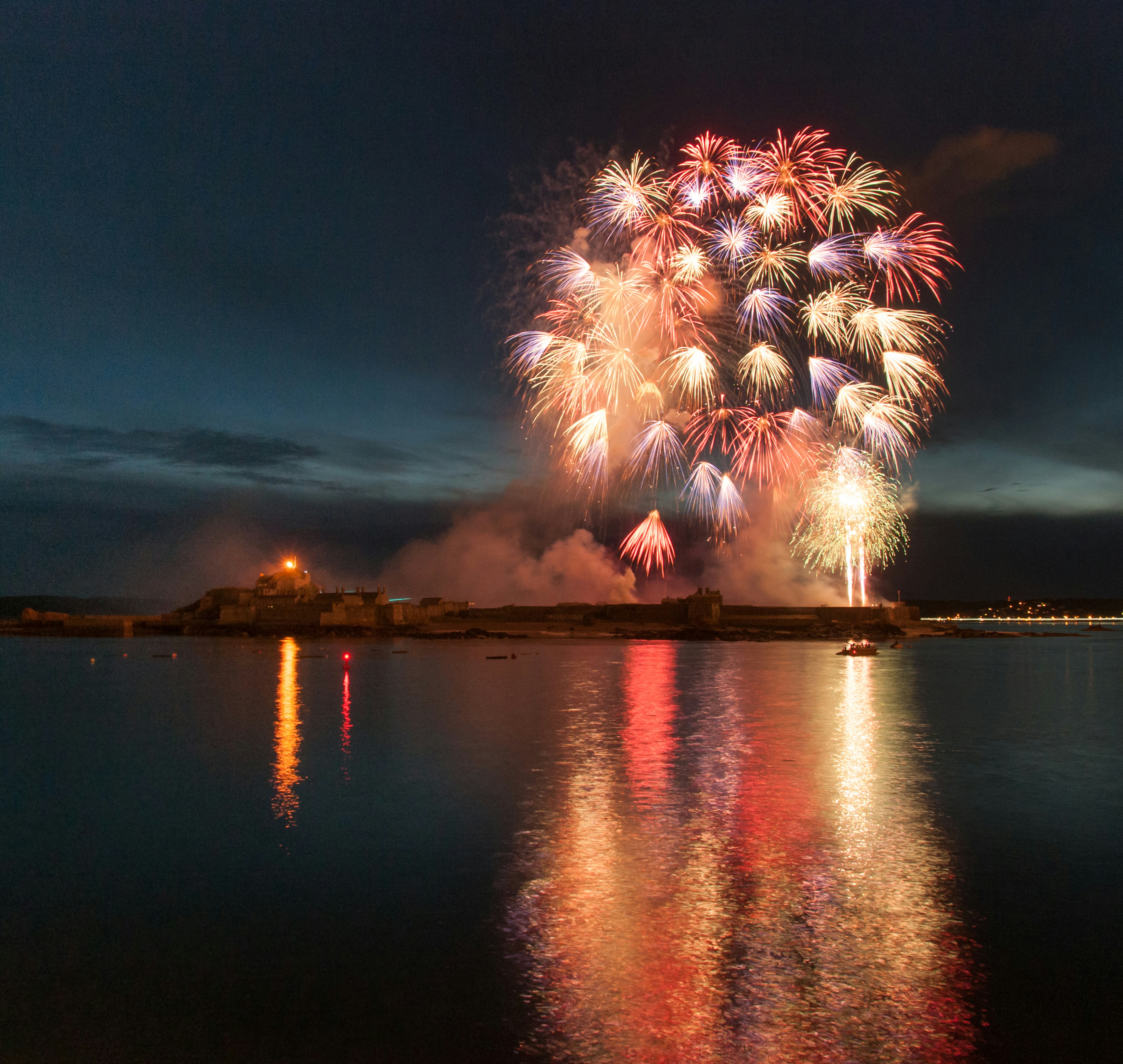 A large fireworks display over a body of water photo – Free Fireworks ...