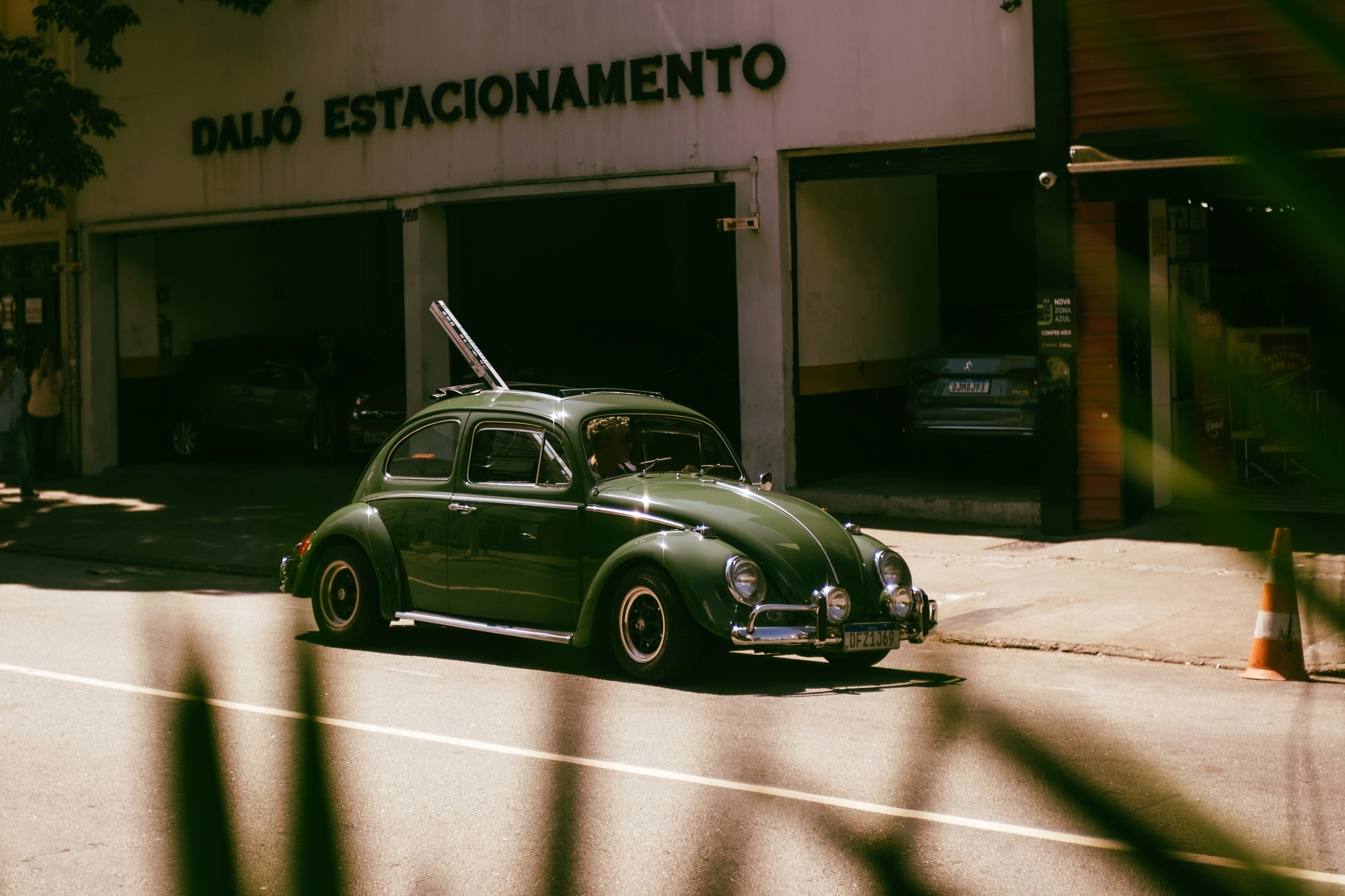 Urban Nostalgia: The Green Beetle Beside a Retro Garage