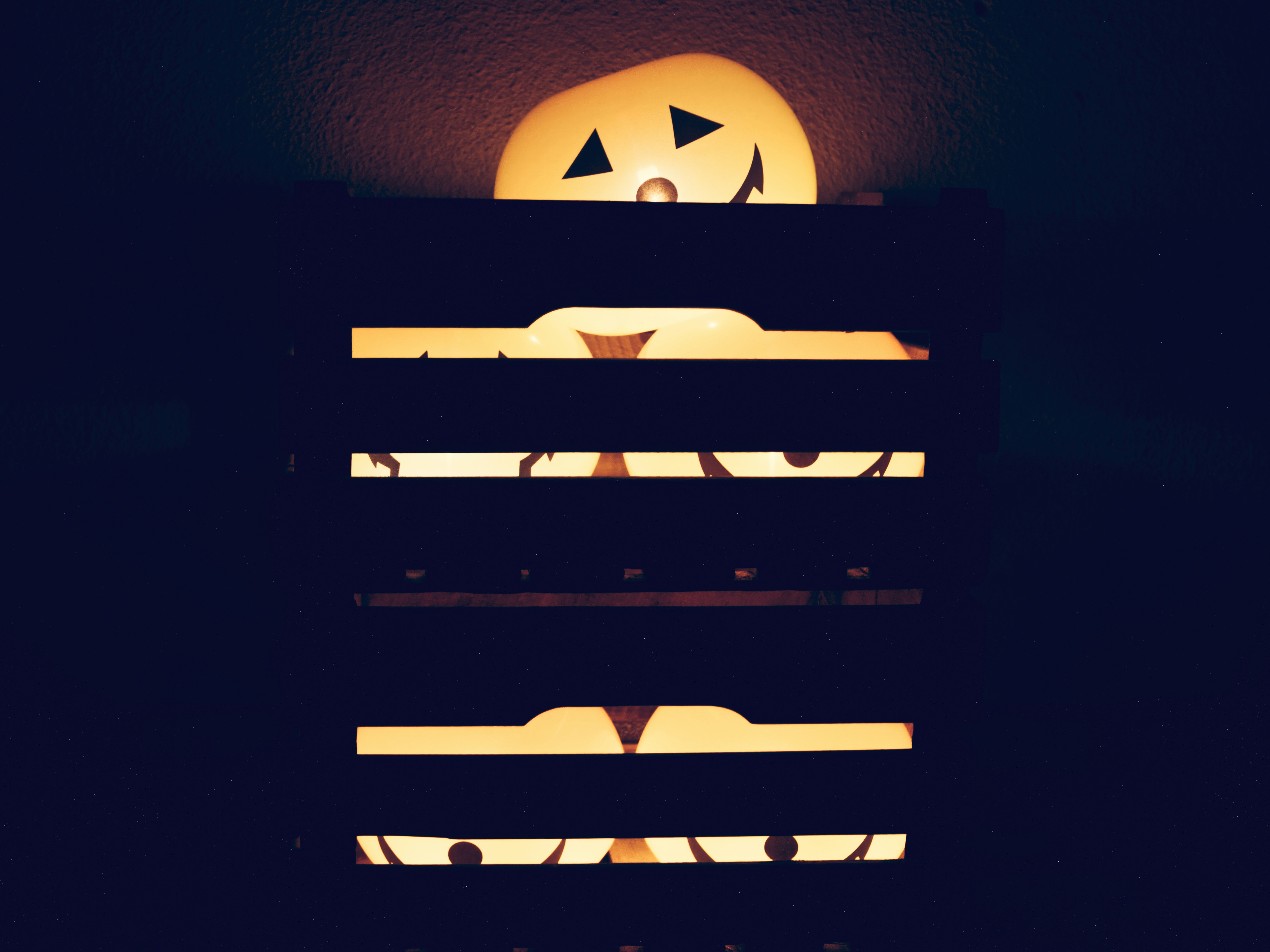 Peeking Pumpkin: A Quiet Halloween Glow Through Wooden Slats