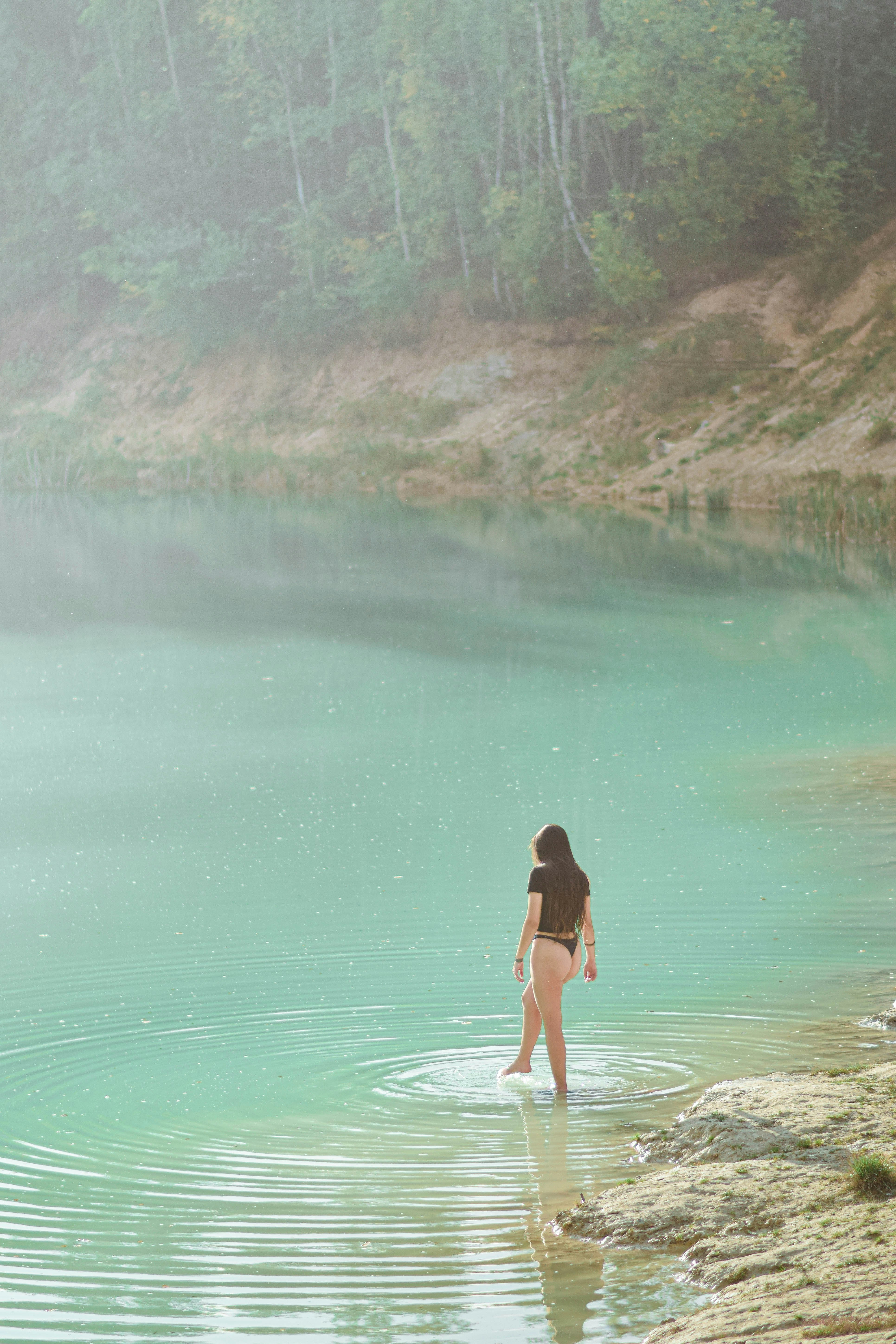 Emerald Quiet: a lone figure in a mist-kissed turquoise lake