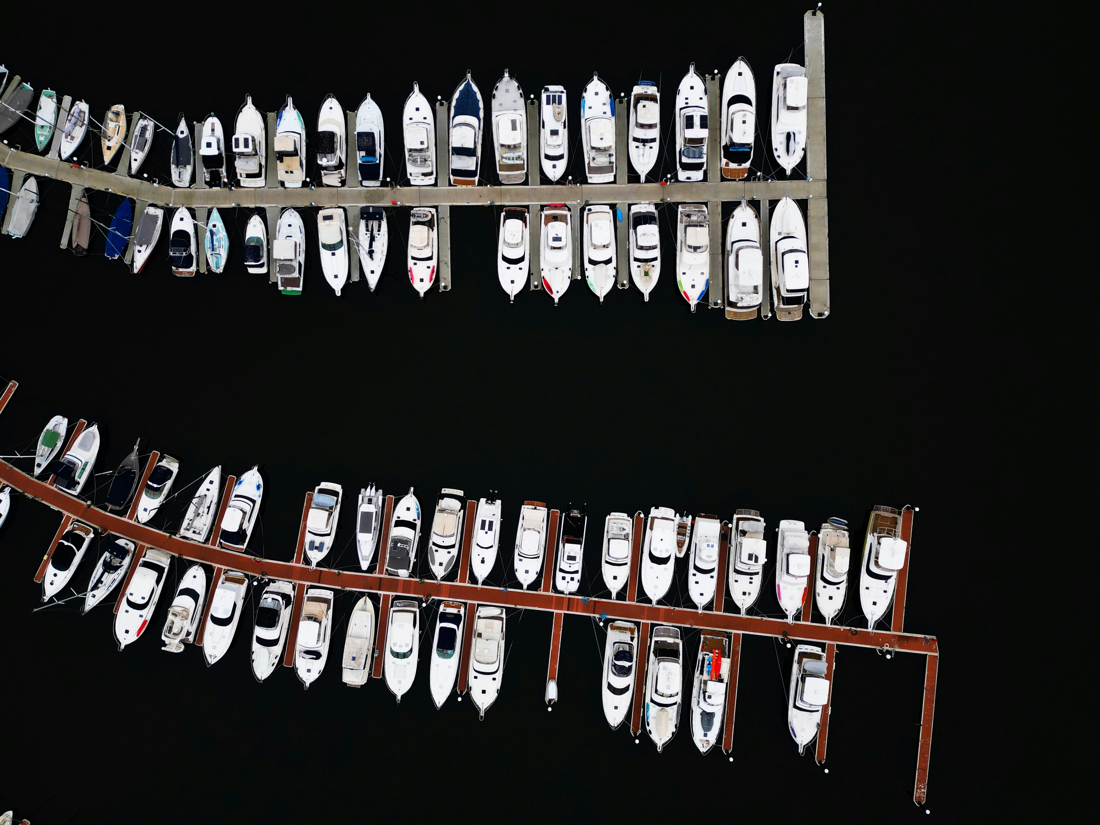 Vertical Marina Grid: Aerial View of Boats Docked in Parallel Ramps