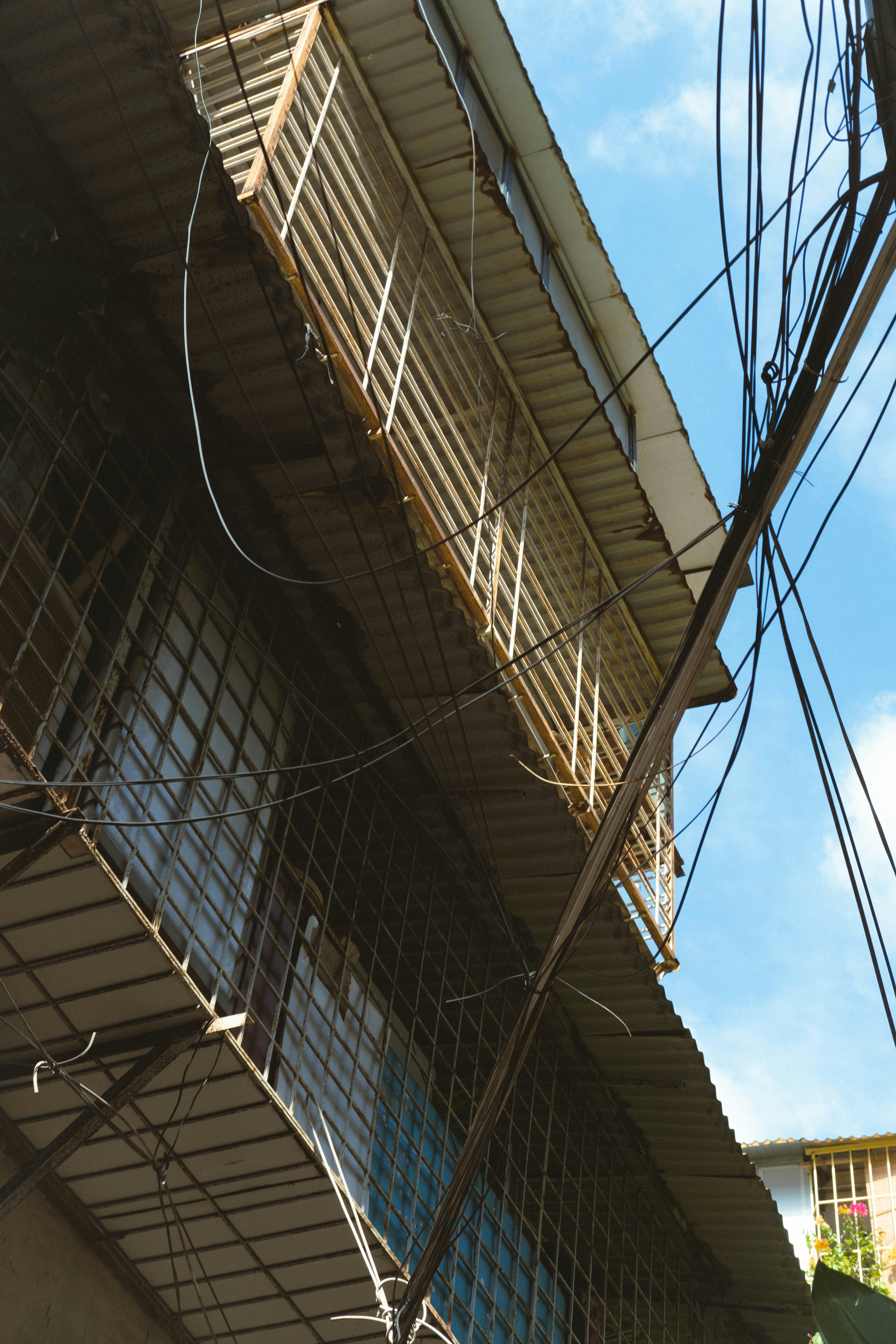A building that has a bunch of wires hanging from it photo – Free ...