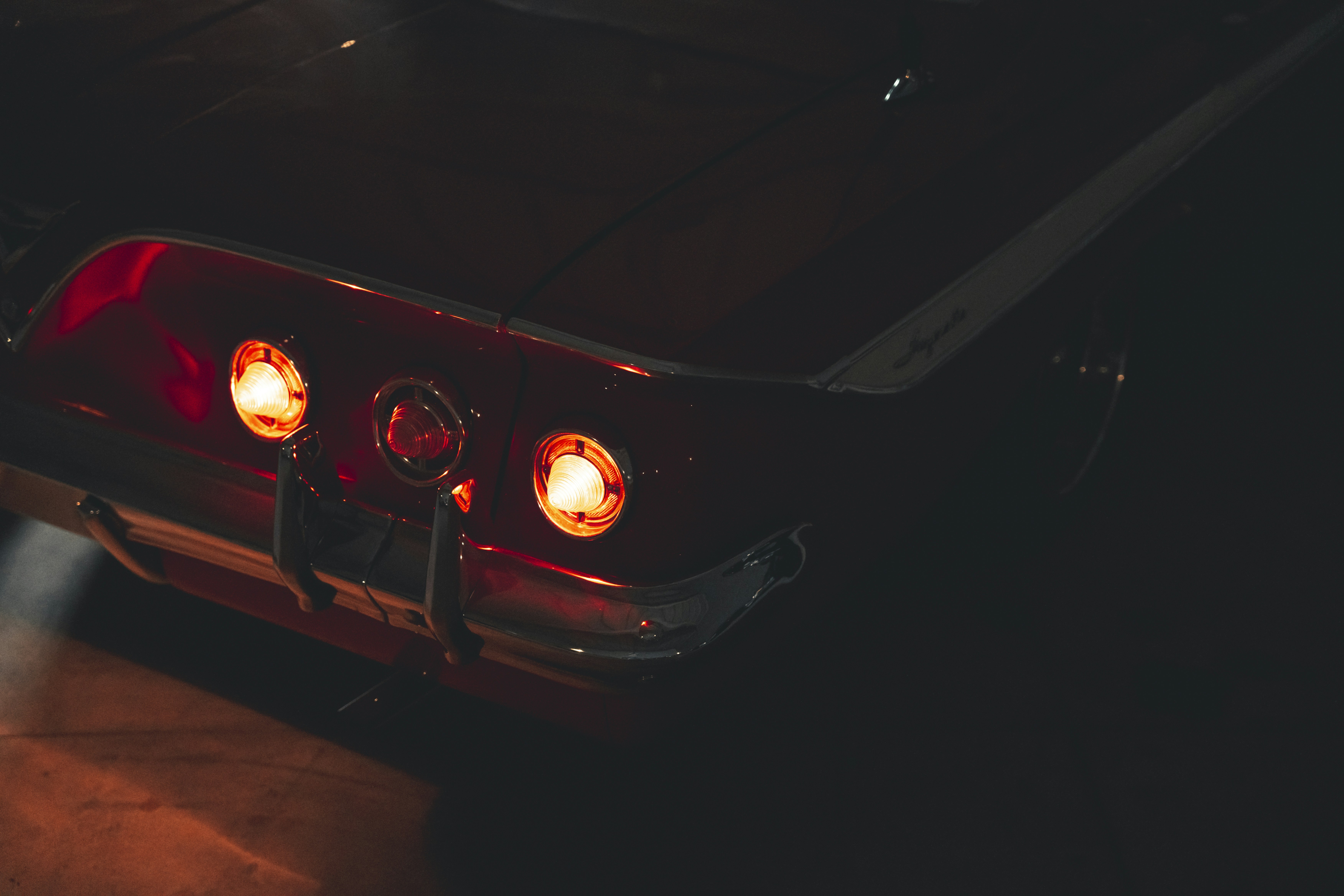 Three Red Orbs in Velvet Darkness: A Vintage Car's Tail-Light Portrait