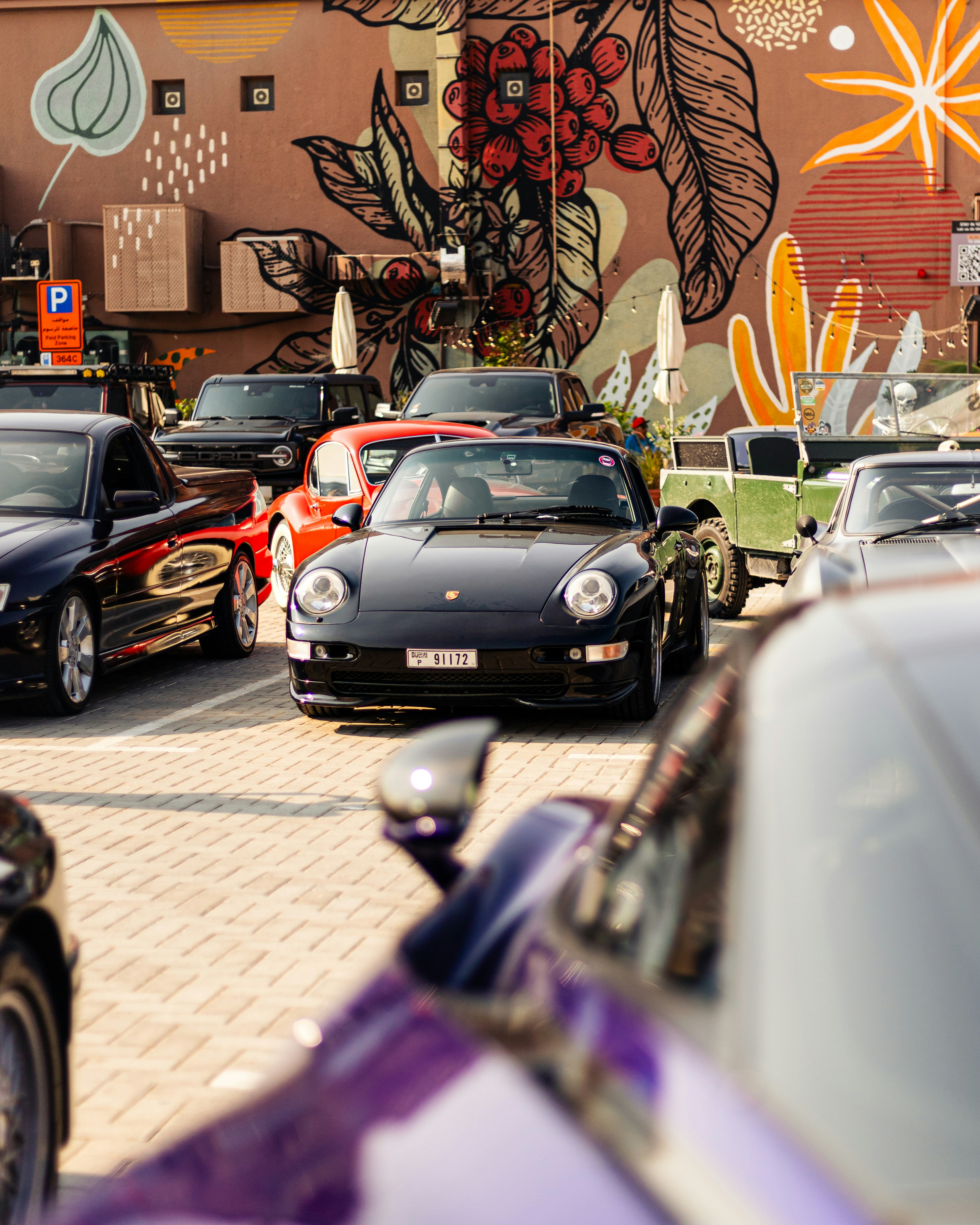Center Stage: A Row of Sleek Cars Framed by a Vivid Wall