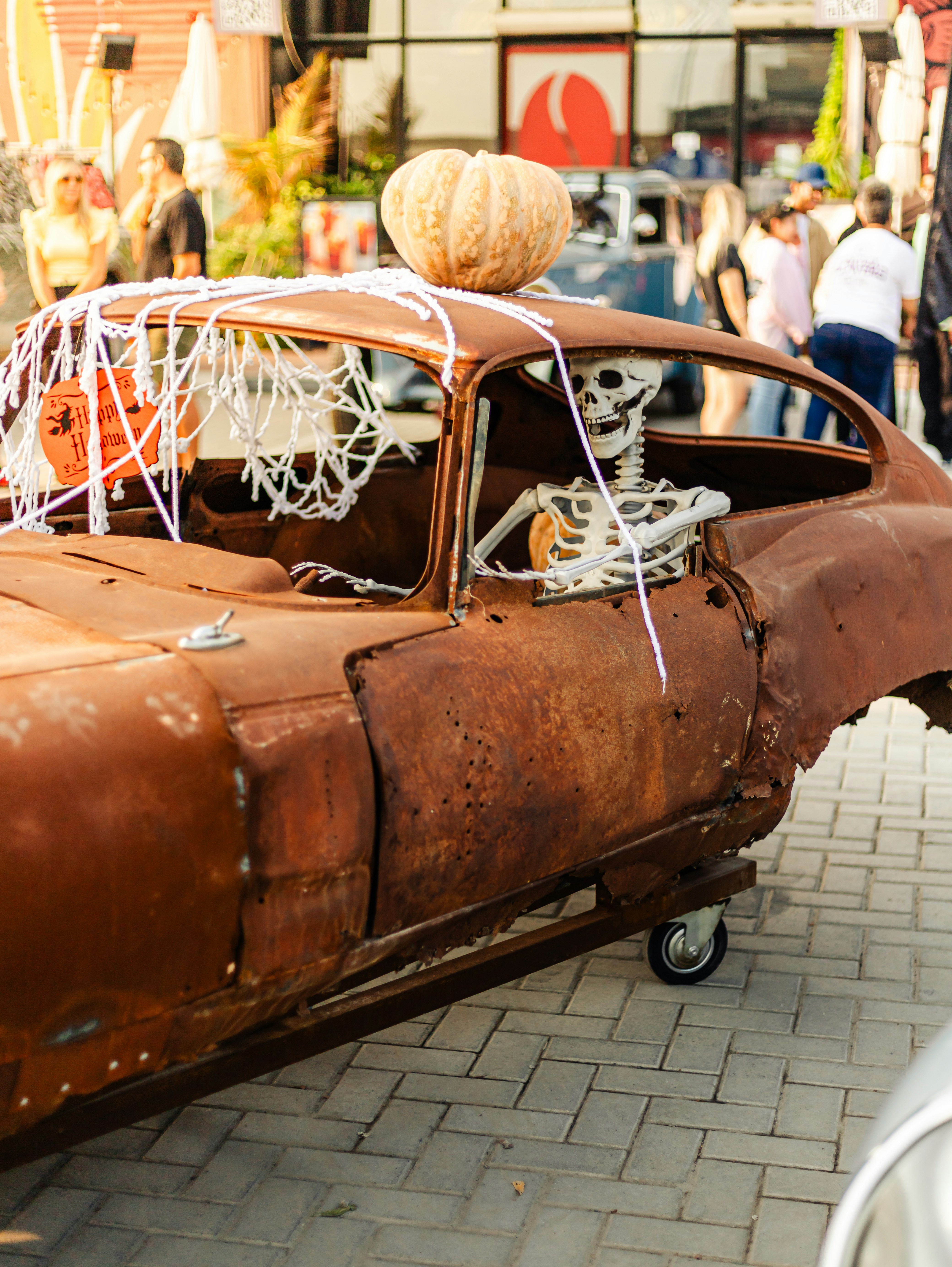 Pumpkin on Chrome: A Rusted Car and Halloween Gaze