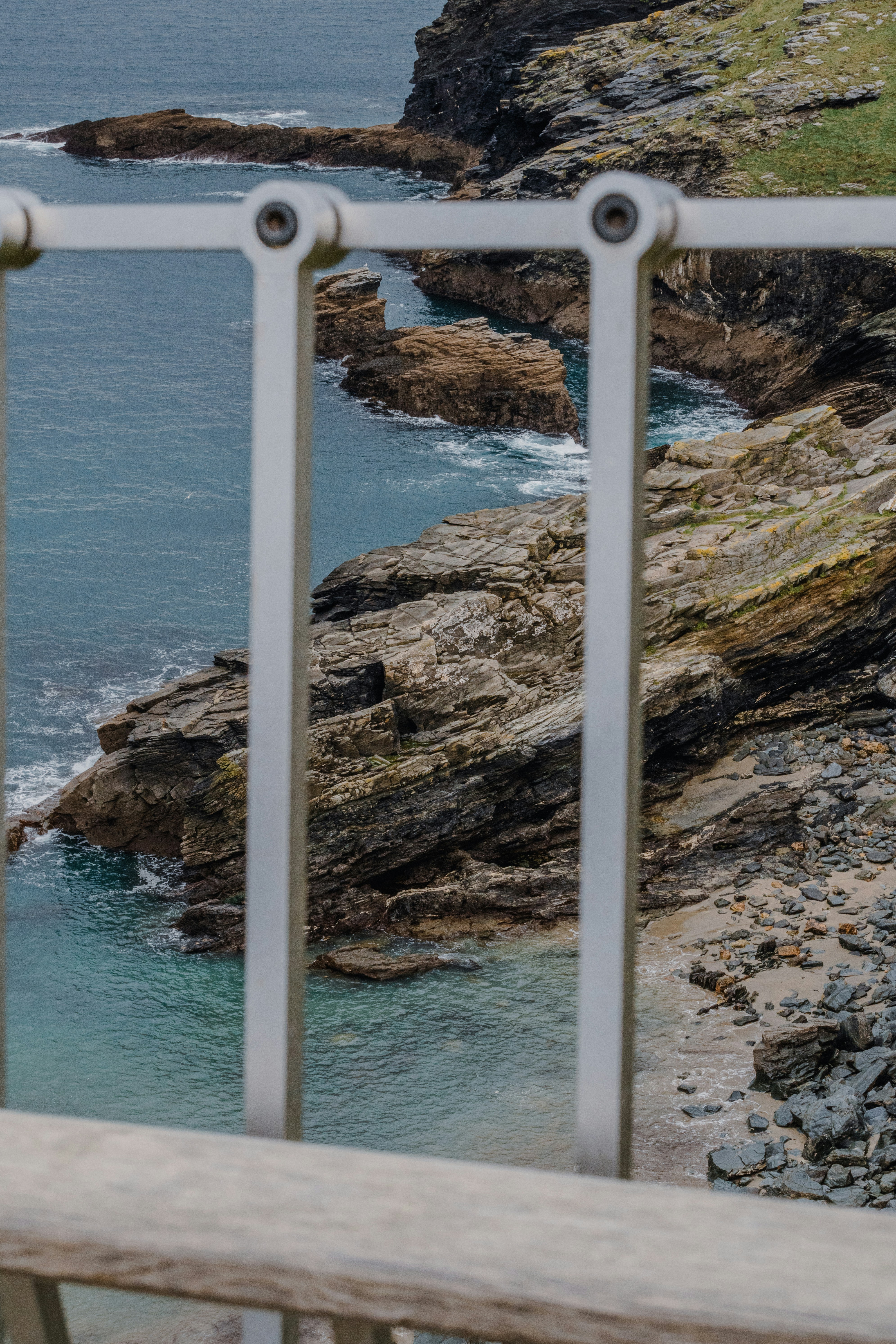 Rugged coastline beyond a weathered railing
