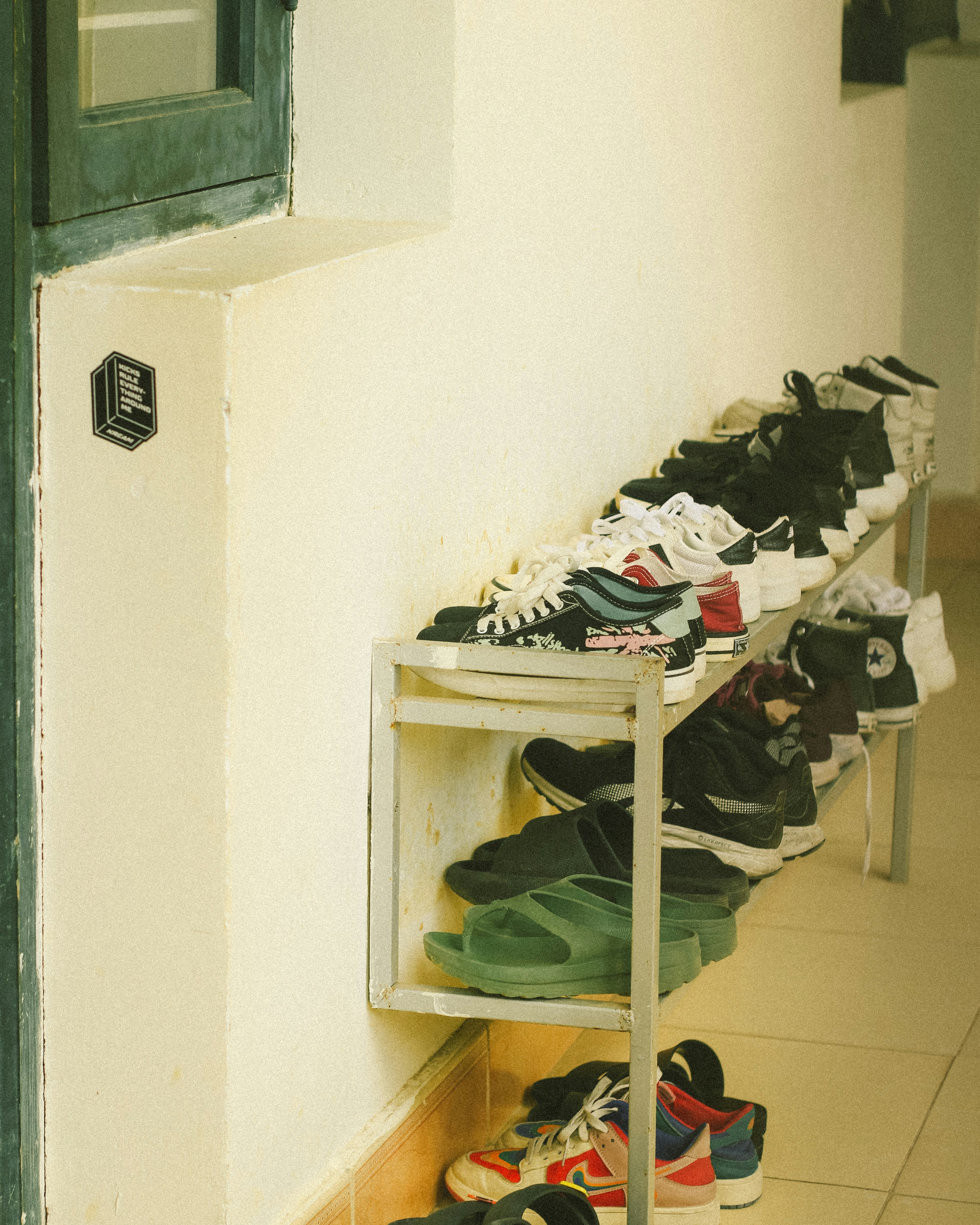 Linear Shoe Gallery: Sneakers Stacked Along a Sunlit Corridor