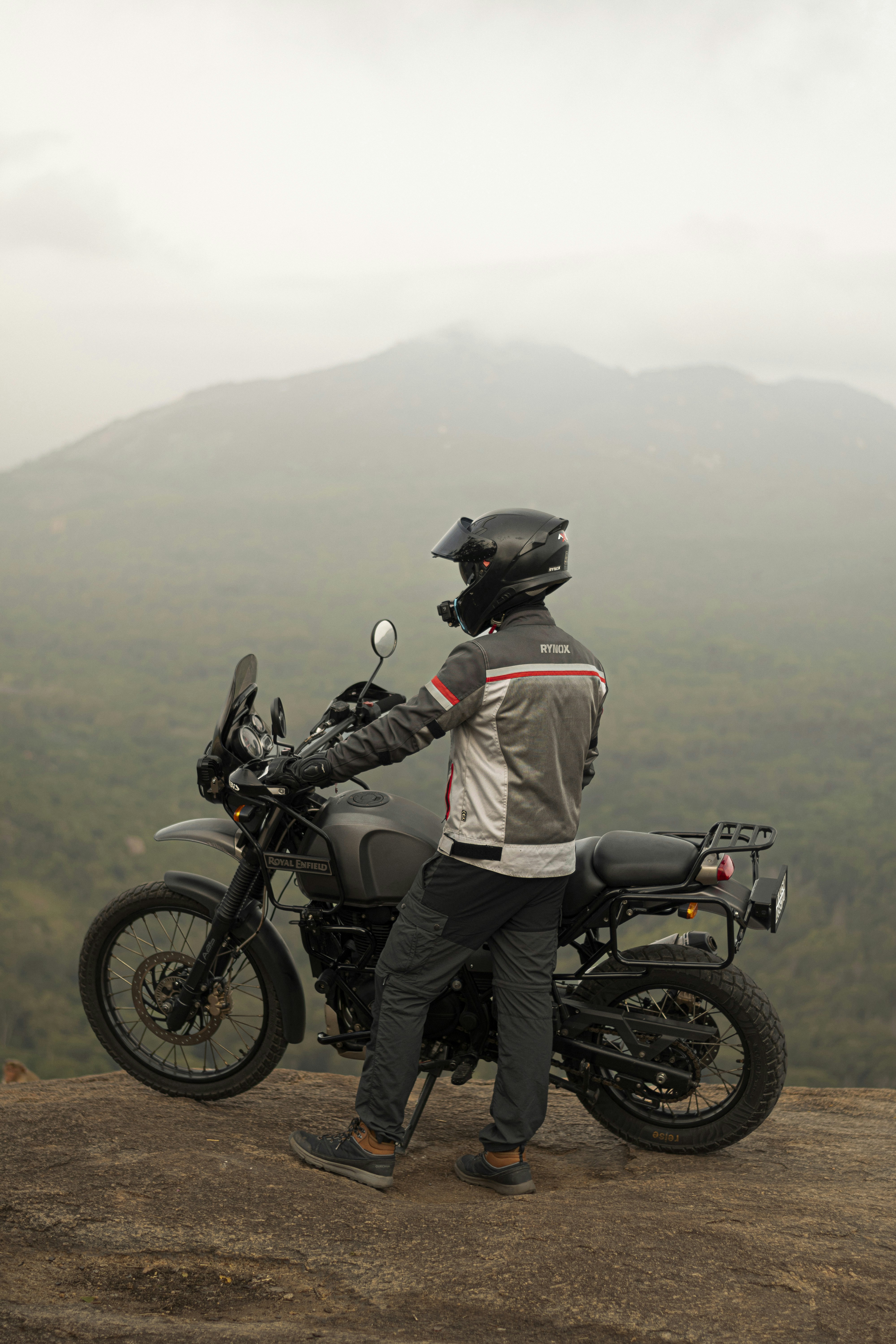 Mistbound Overlook: Rider and Motorcycle on a Cliff