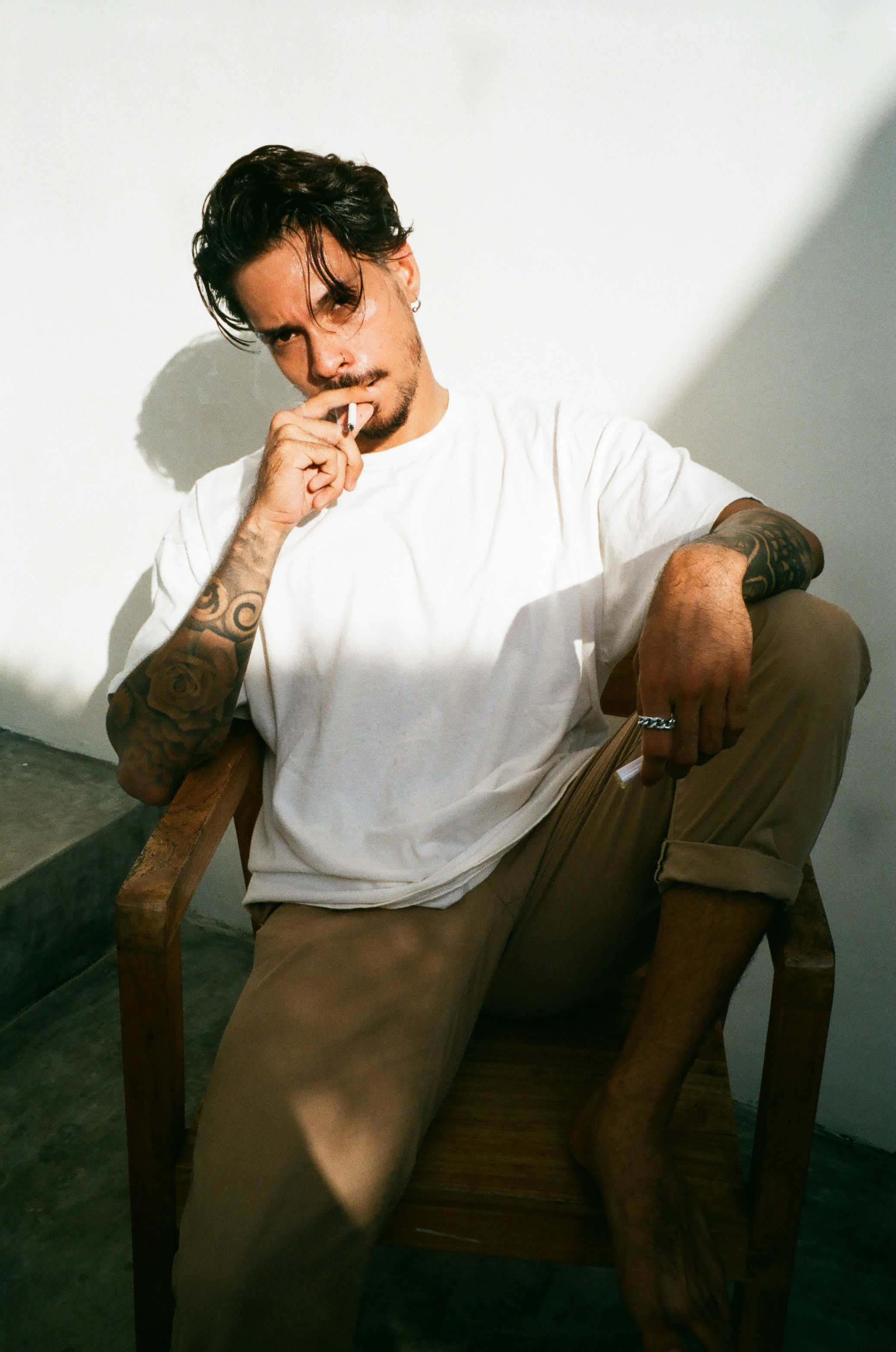 A man sitting in a chair smoking a cigarette photo – Free Style Image ...