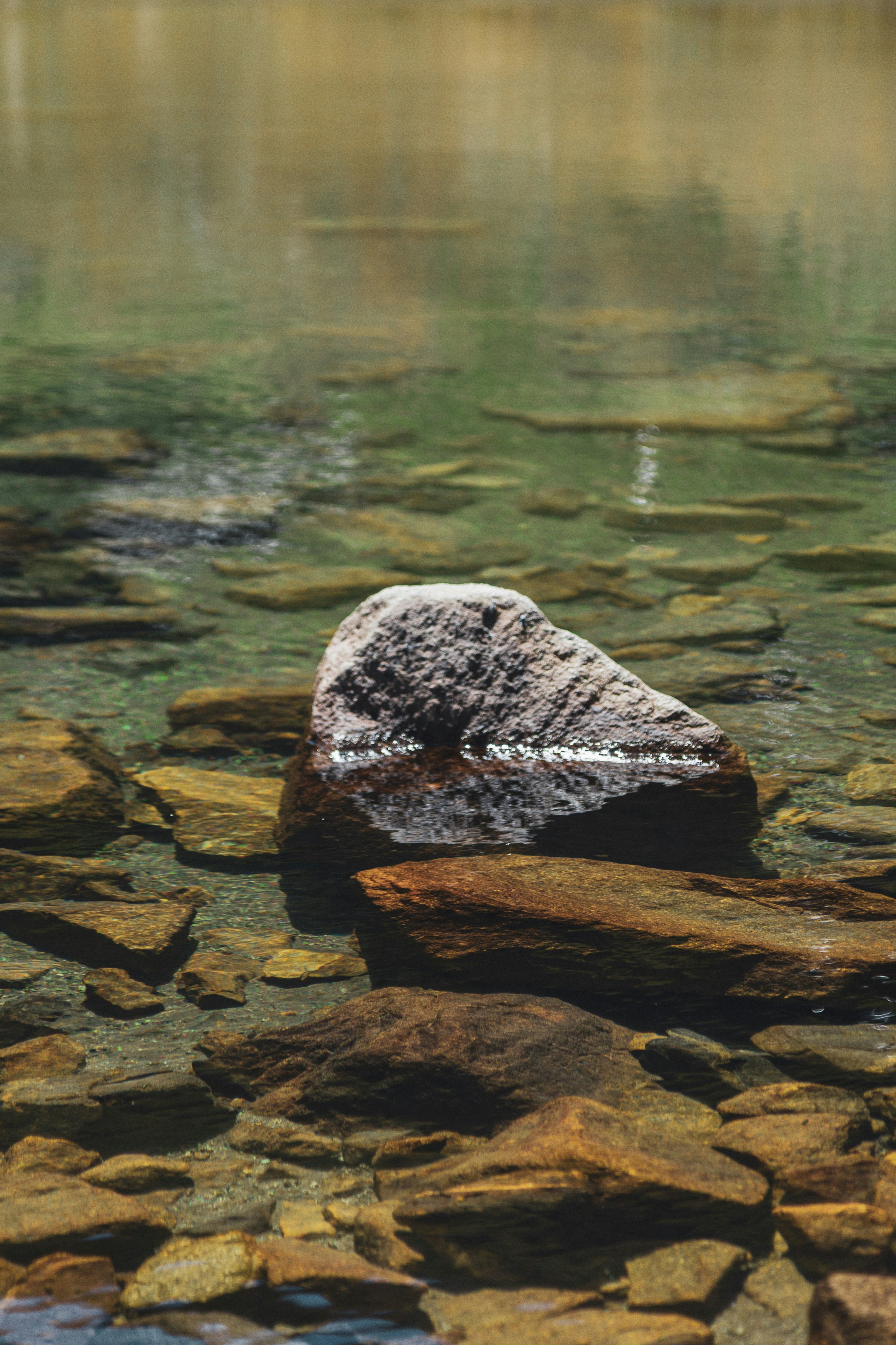 A rock sitting on top of a rock covered in water photo – Free Pelister ...
