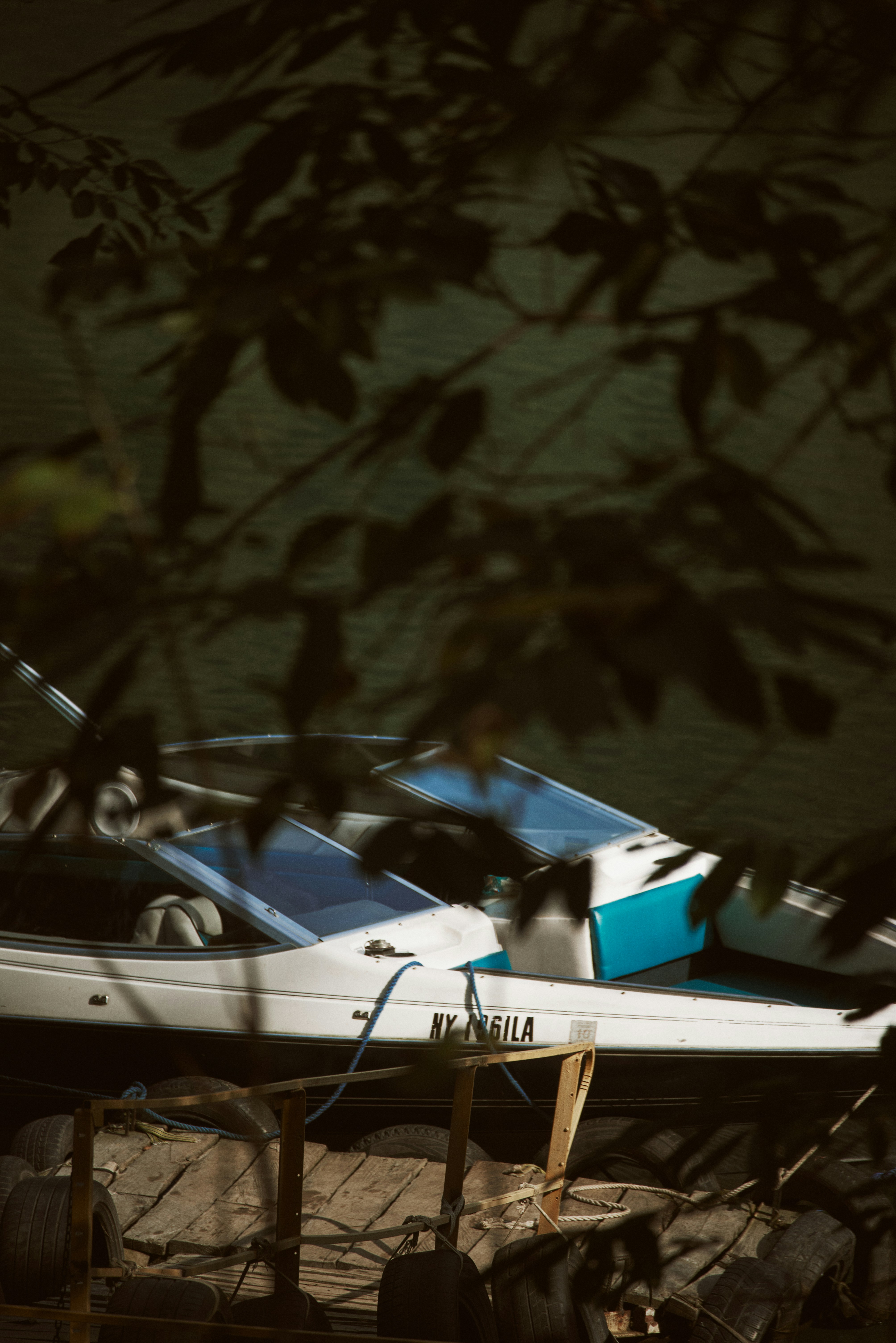 a white and blue boat sitting on top of a wooden dock