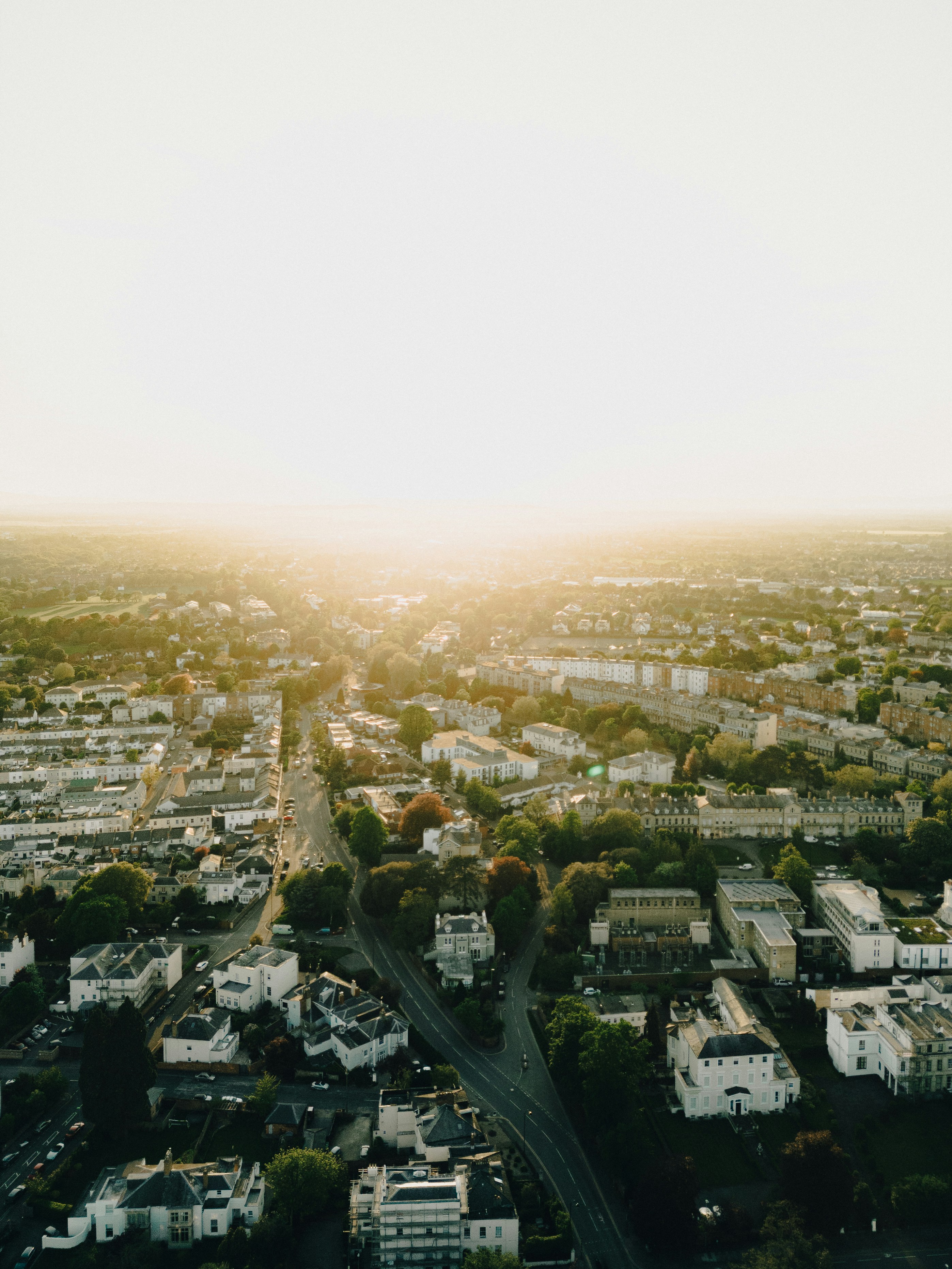 Sun setting over Cheltenham, casting a warm glow across the town's rooftops and streets.