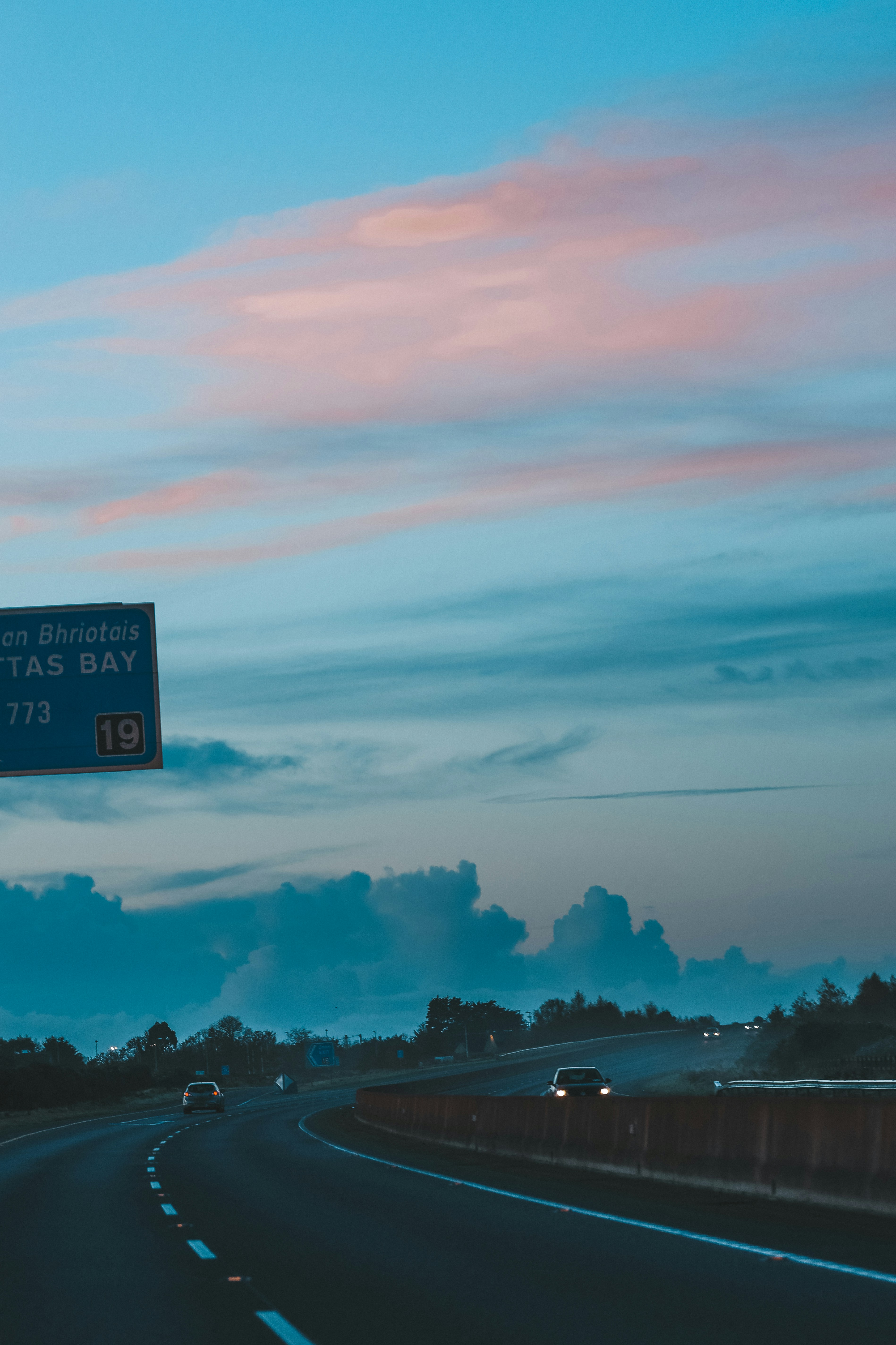 Dusk on the Curve: Pink-Cloud Skies Over a Quiet Highway