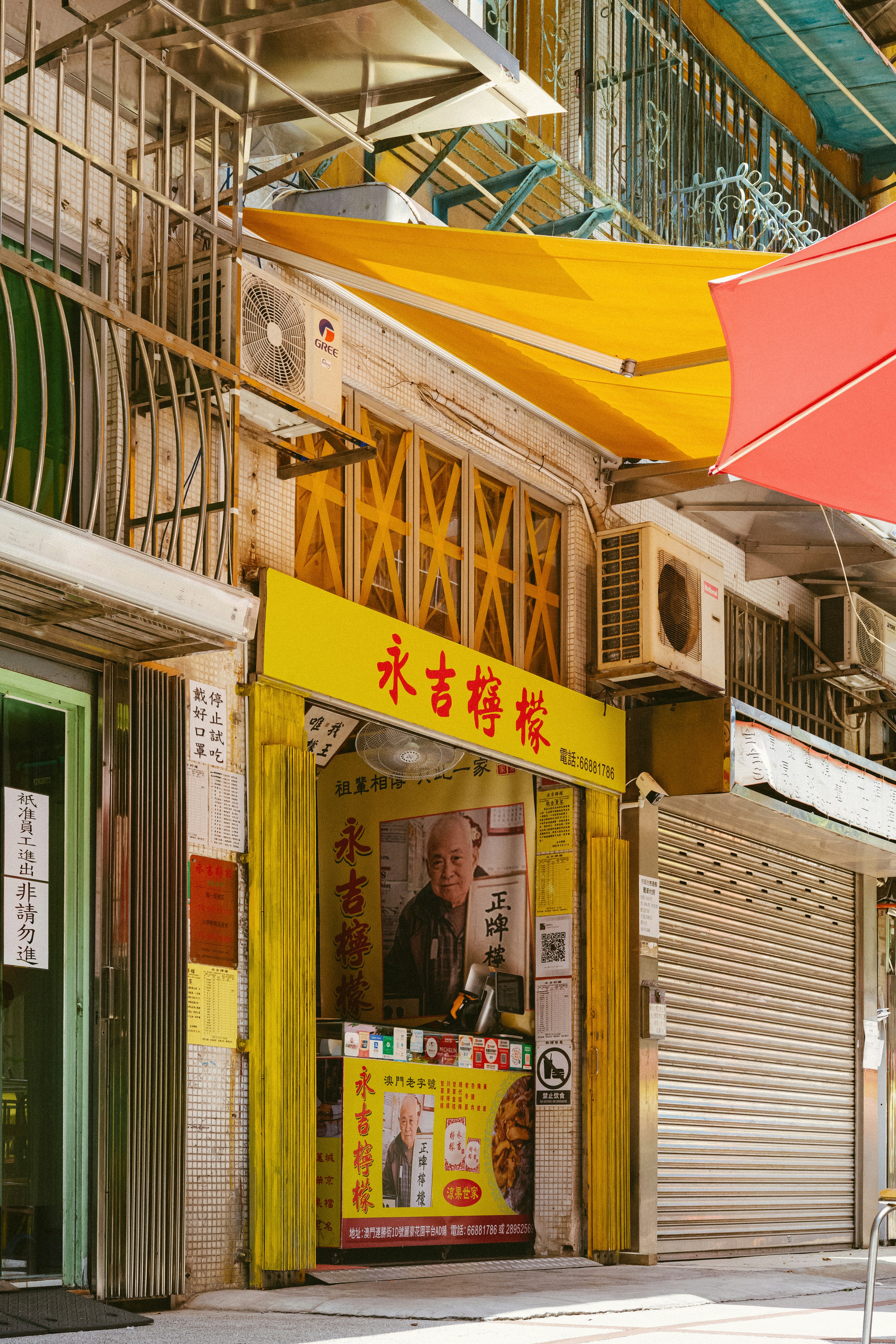 A yellow store front with a red umbrella over it photo – Free Building Image on Unsplash